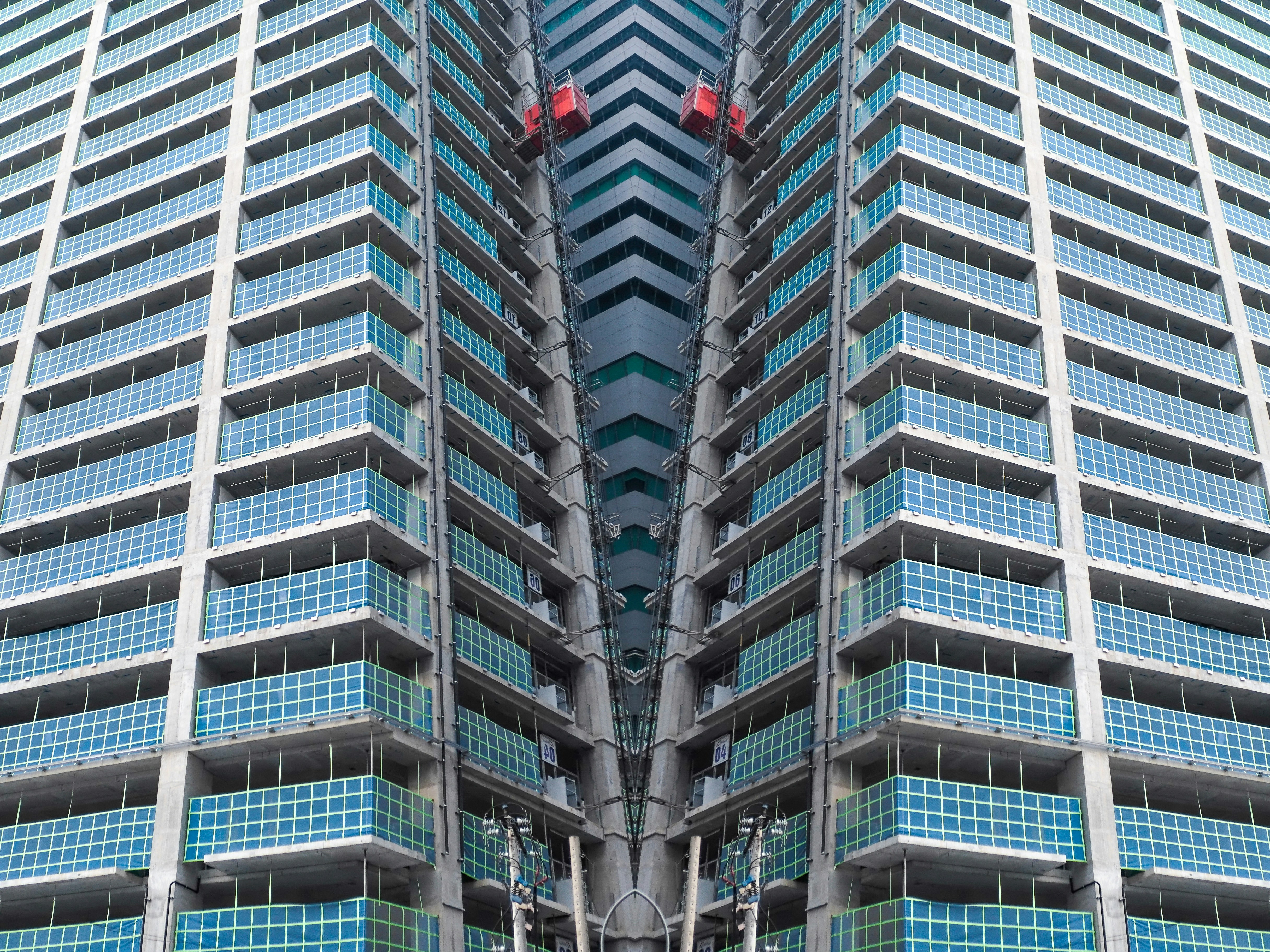 A symmetrical skyscraper reaches towards the sky.