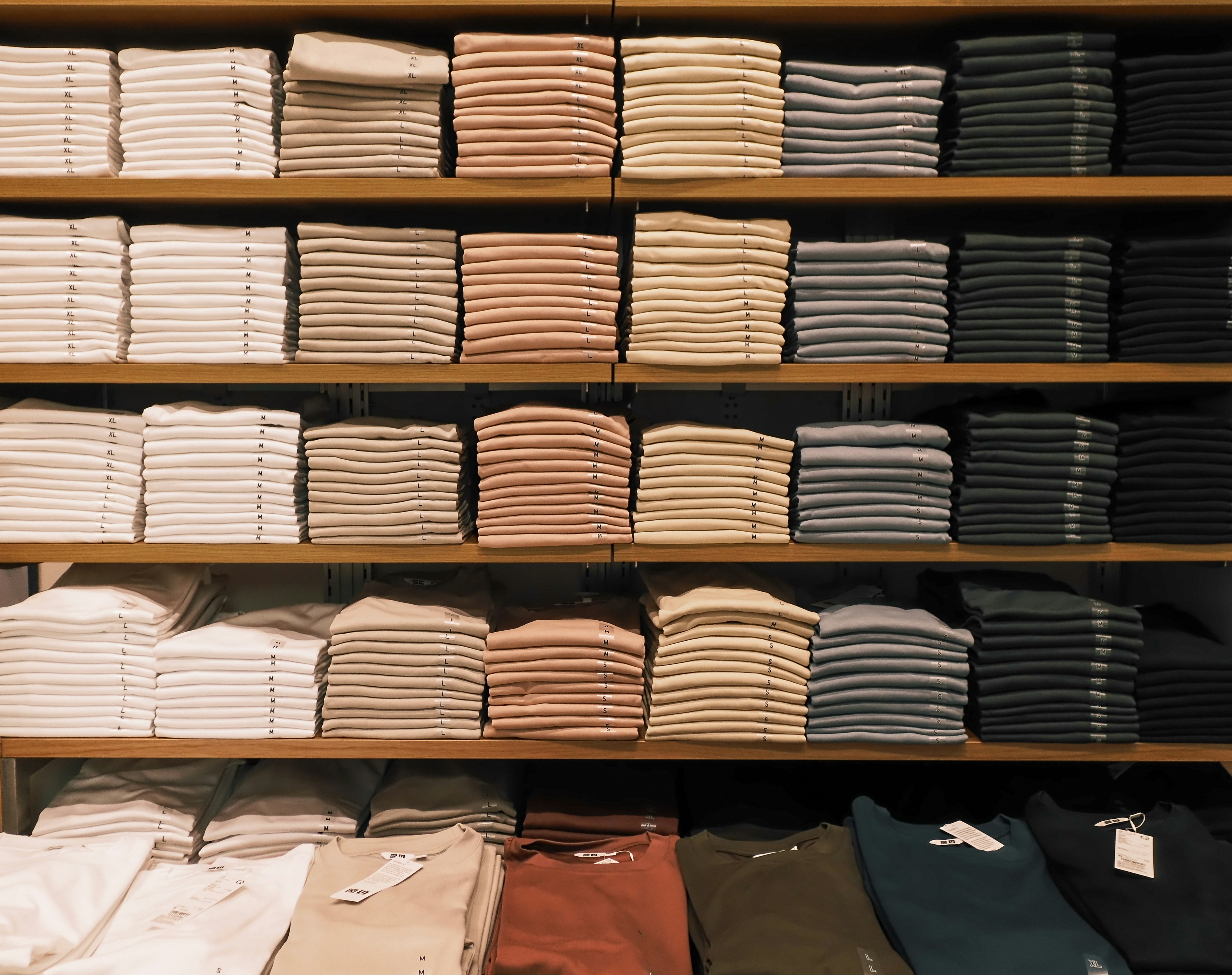 Neatly stacked clothes displayed on shelves.