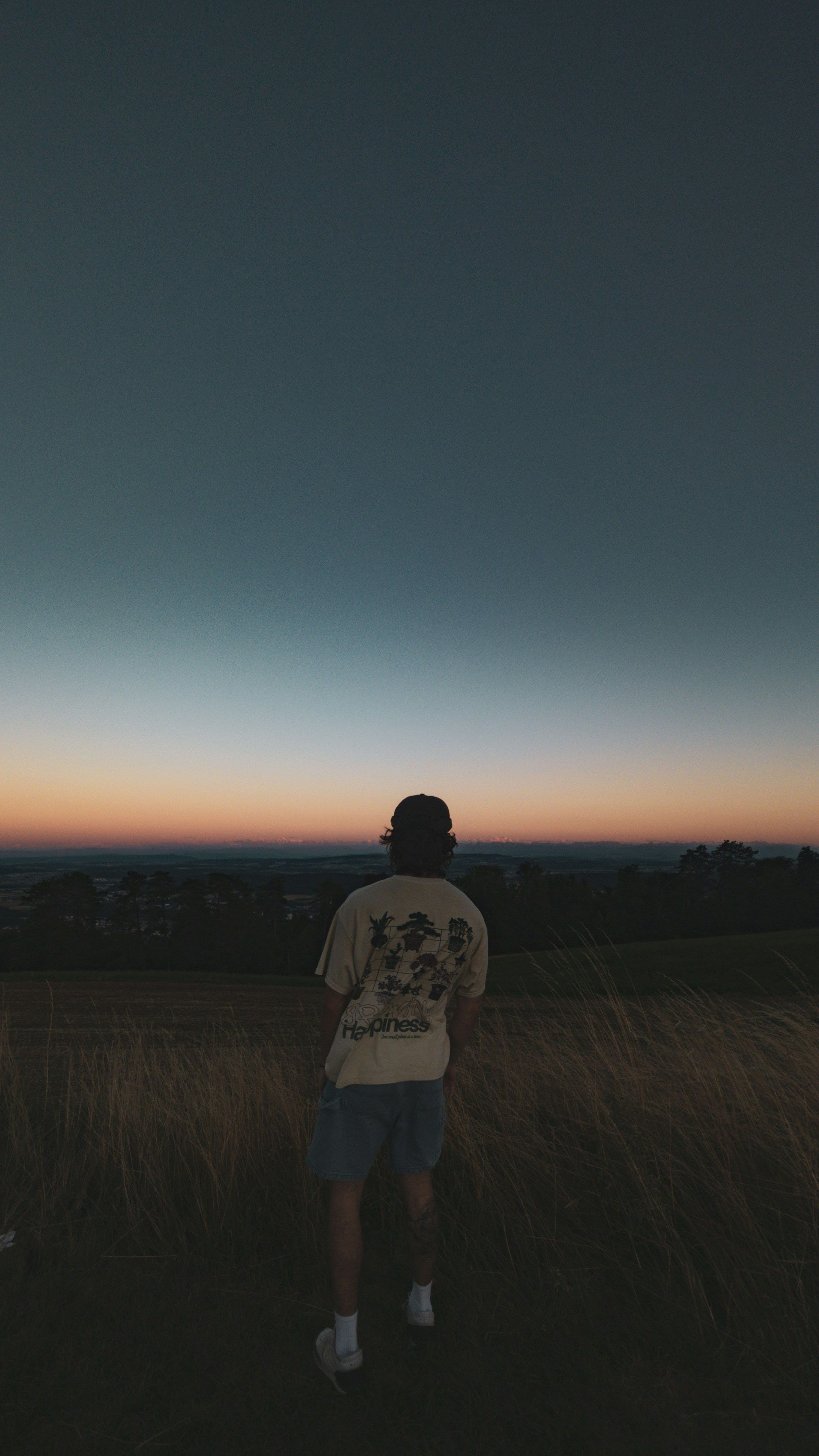 Man stands and watches a sunset.