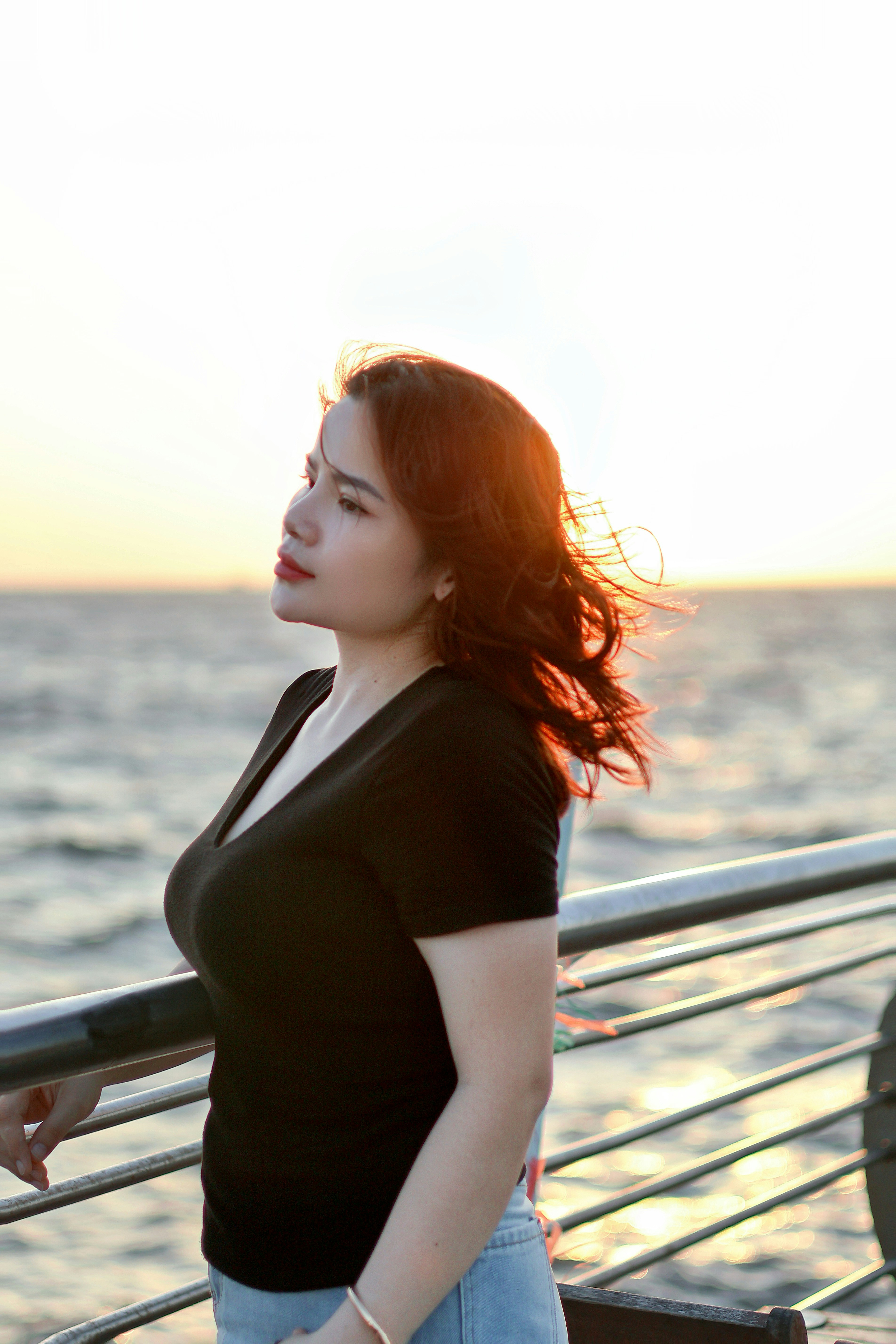 Woman enjoys the sunset by the sea.