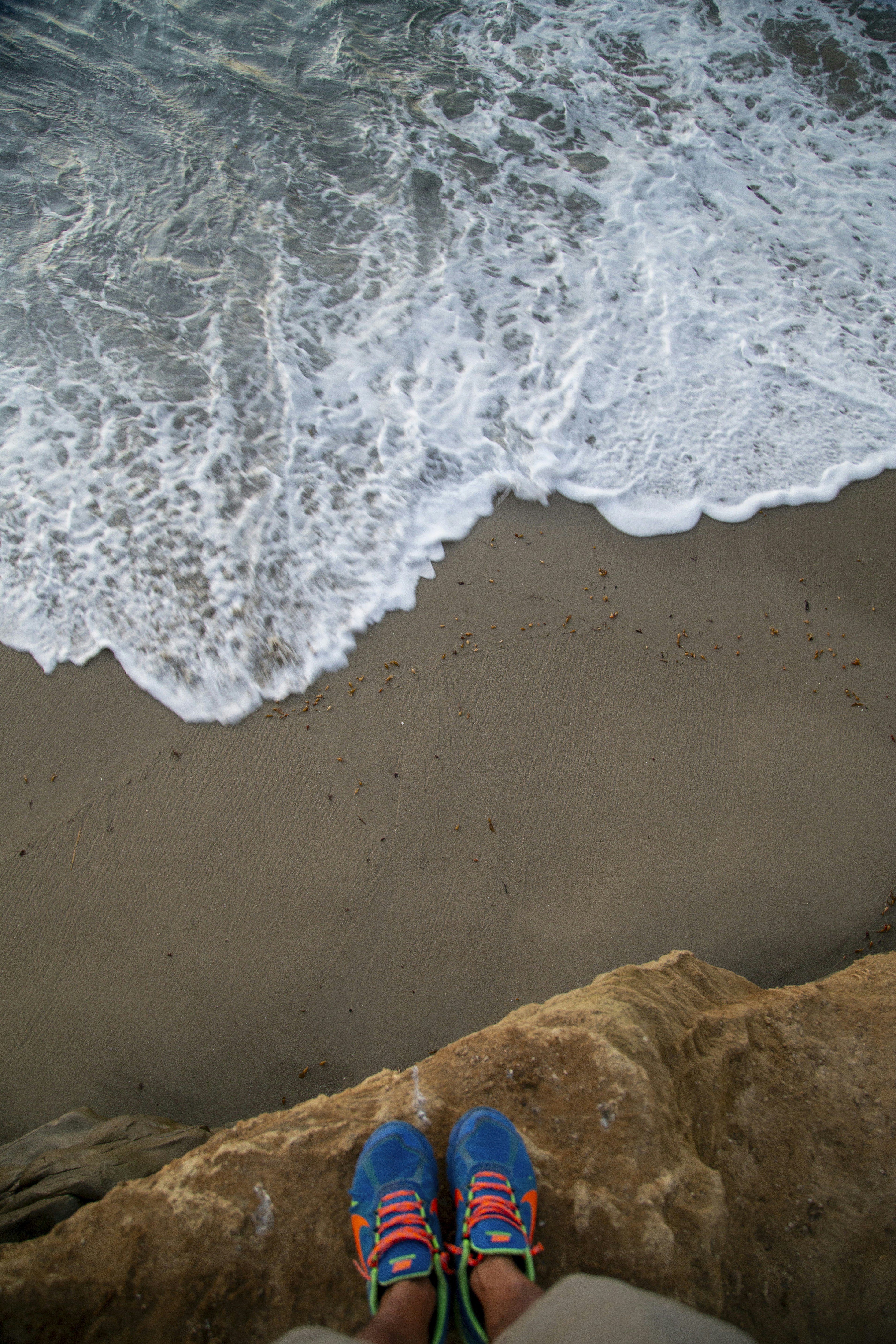 Shoes perched on a cliff overlooking the ocean.