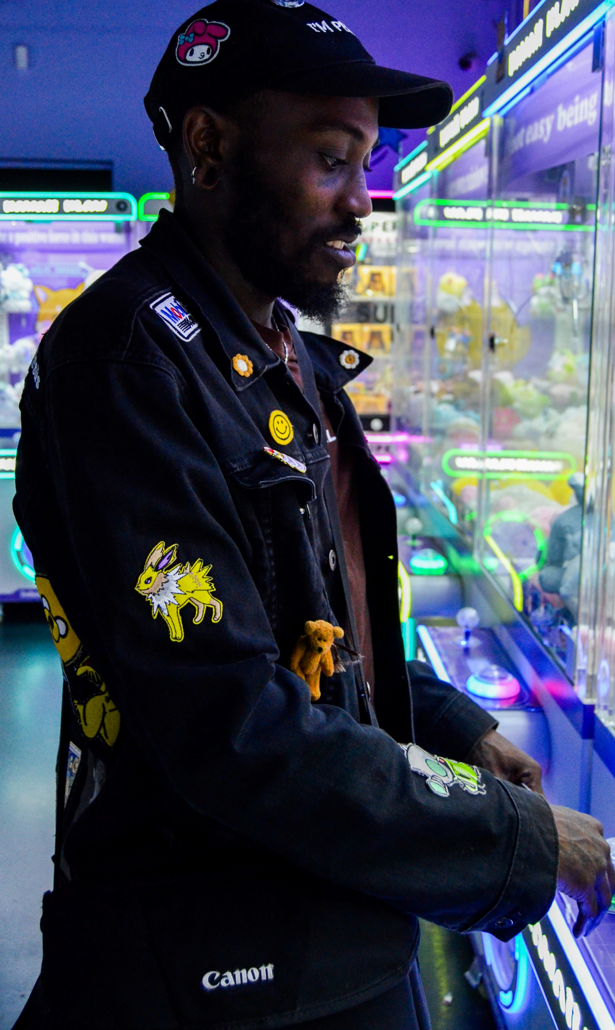 A man plays a claw machine in an arcade.