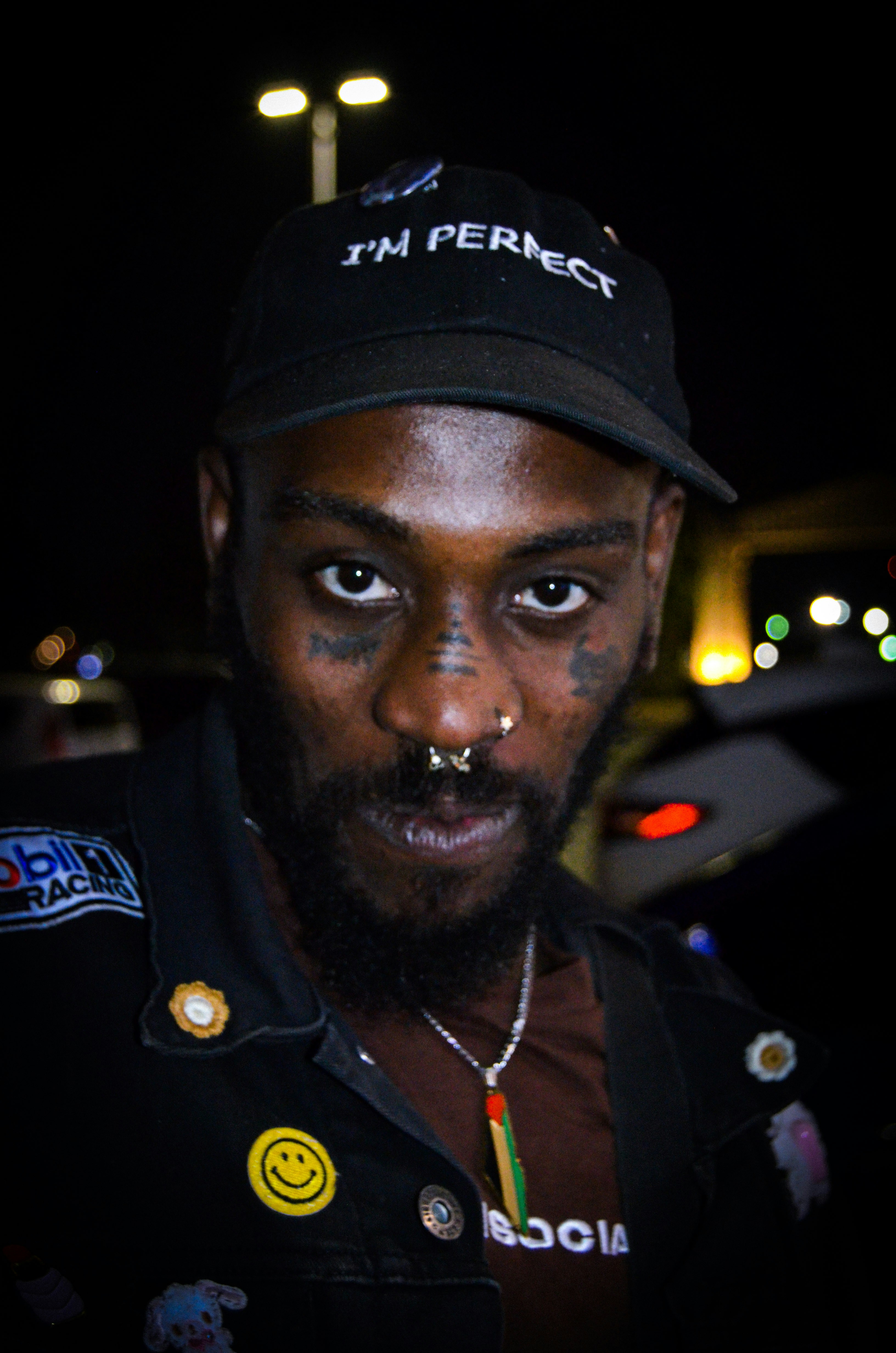 A person wearing a hat with "i'm perfect" on it.