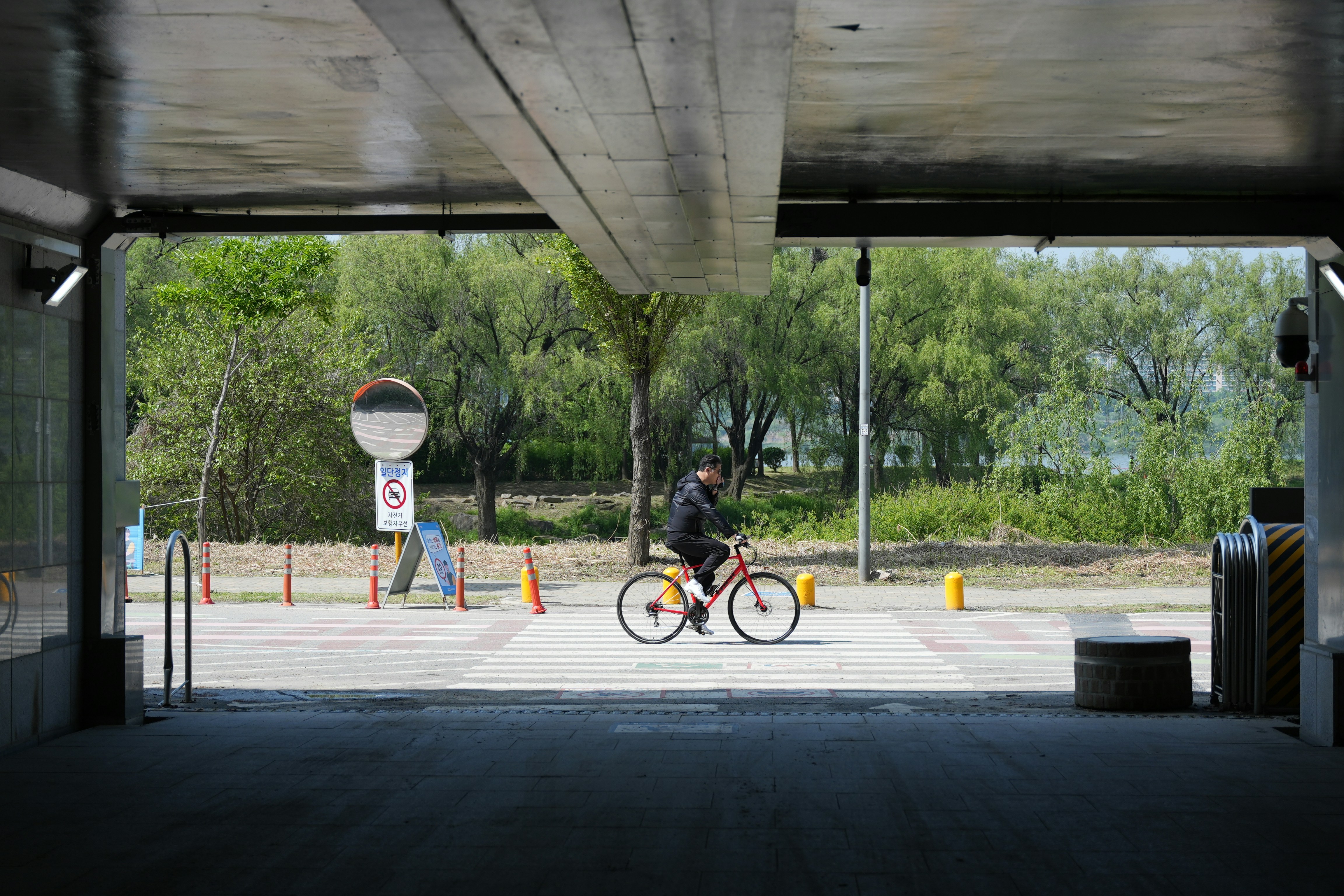 A cyclist rides past an open tunnel.