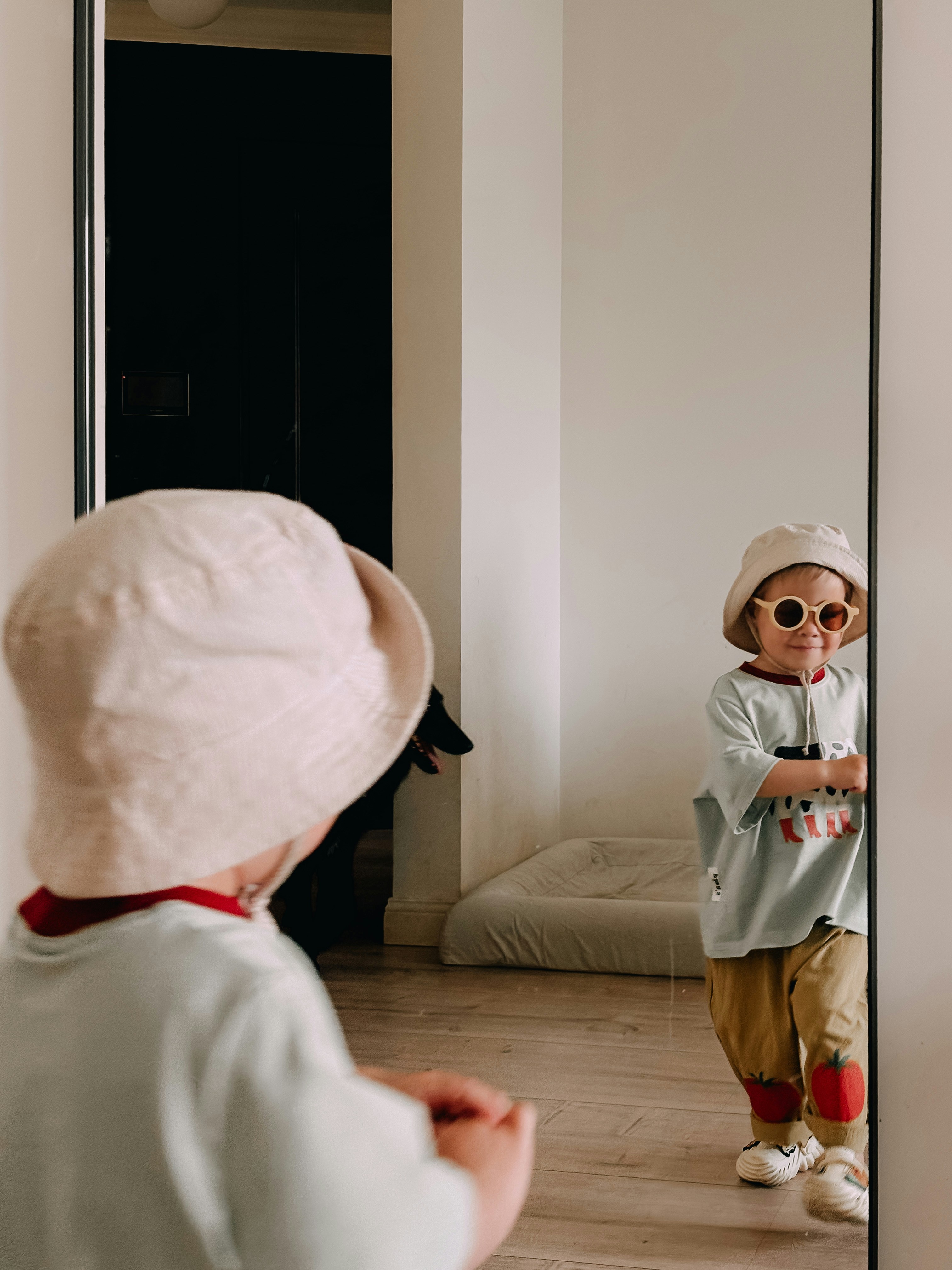 A child poses in front of a mirror.