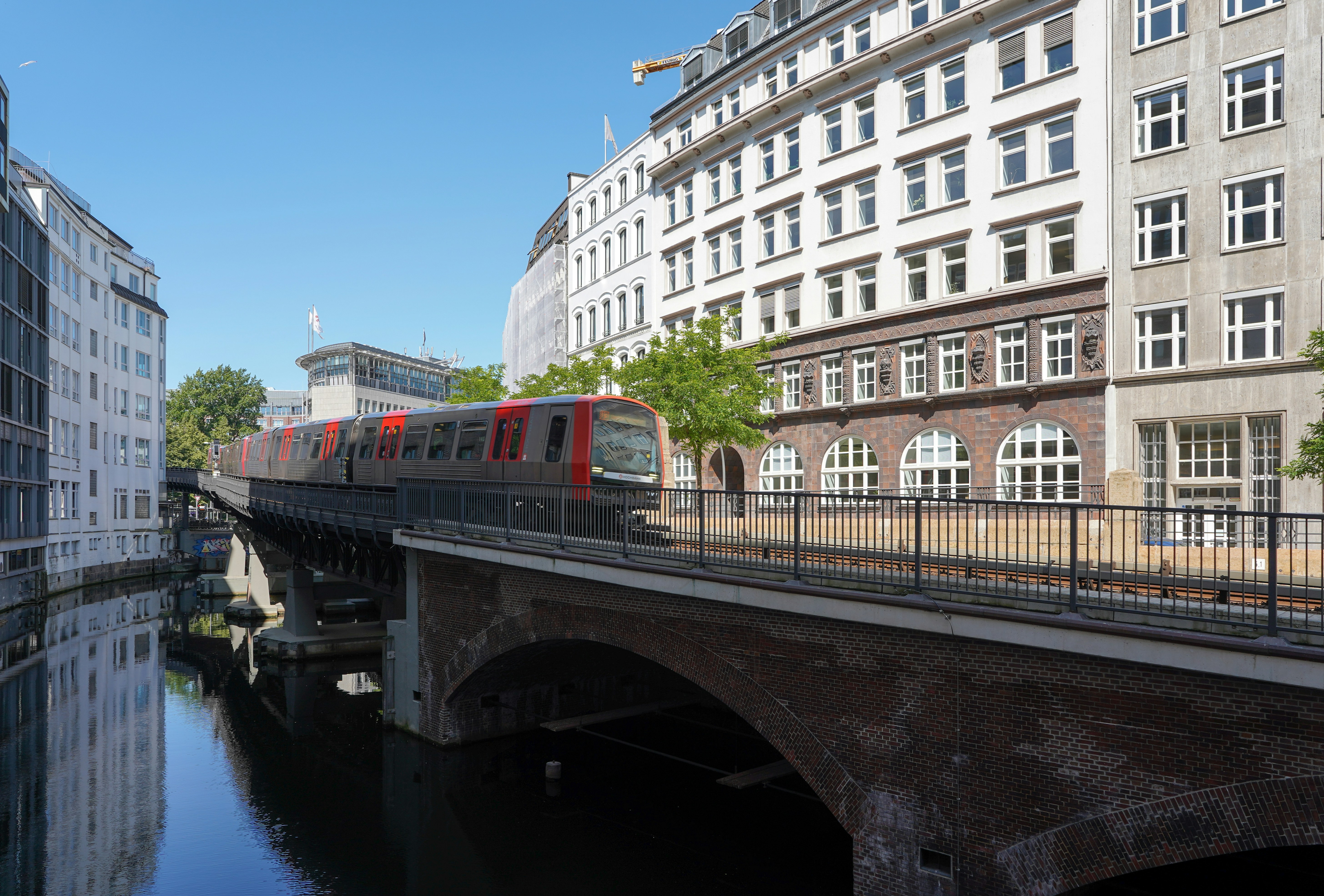 A subway train crosses a bridge in a city.