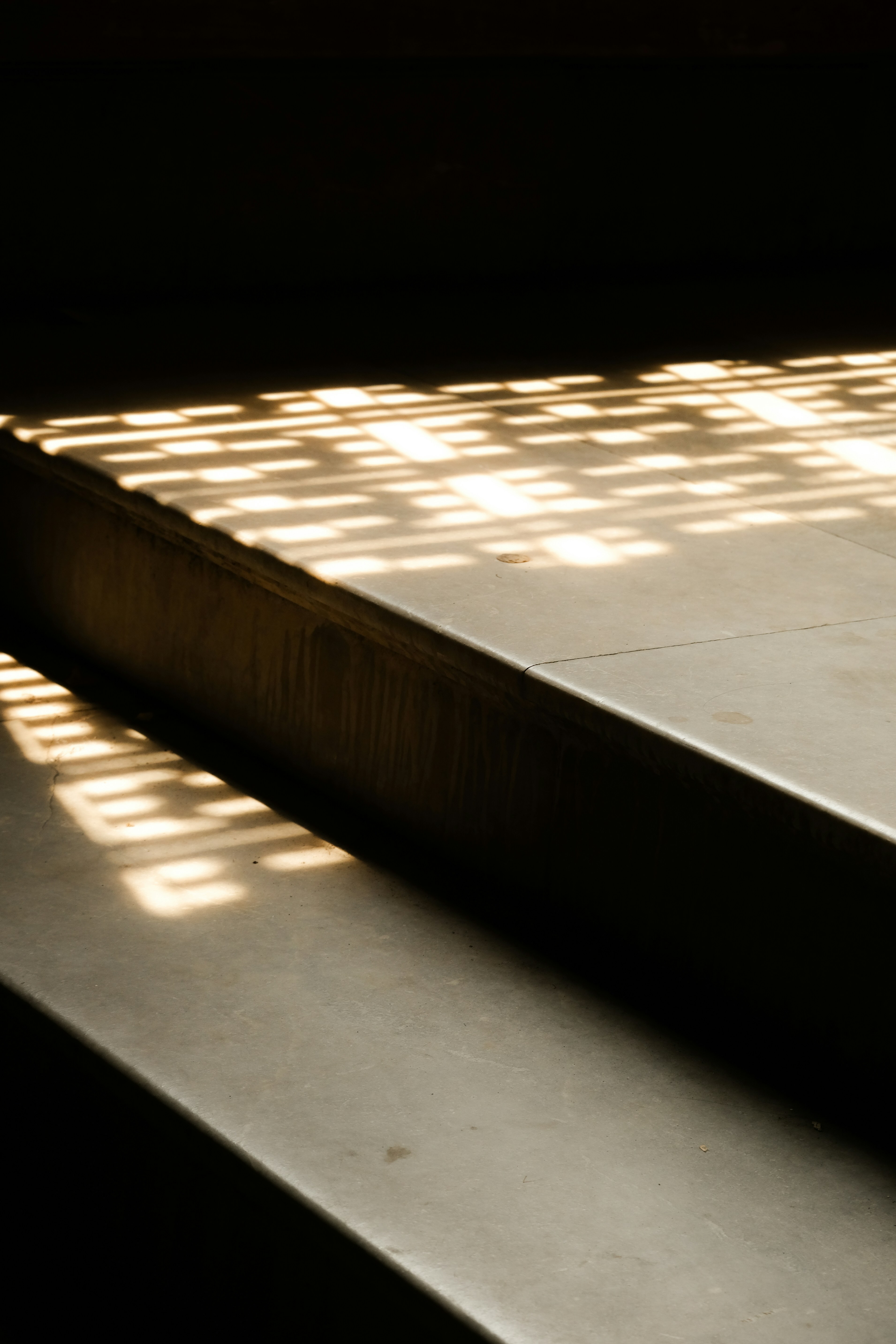 Light and shadow play on a concrete surface.