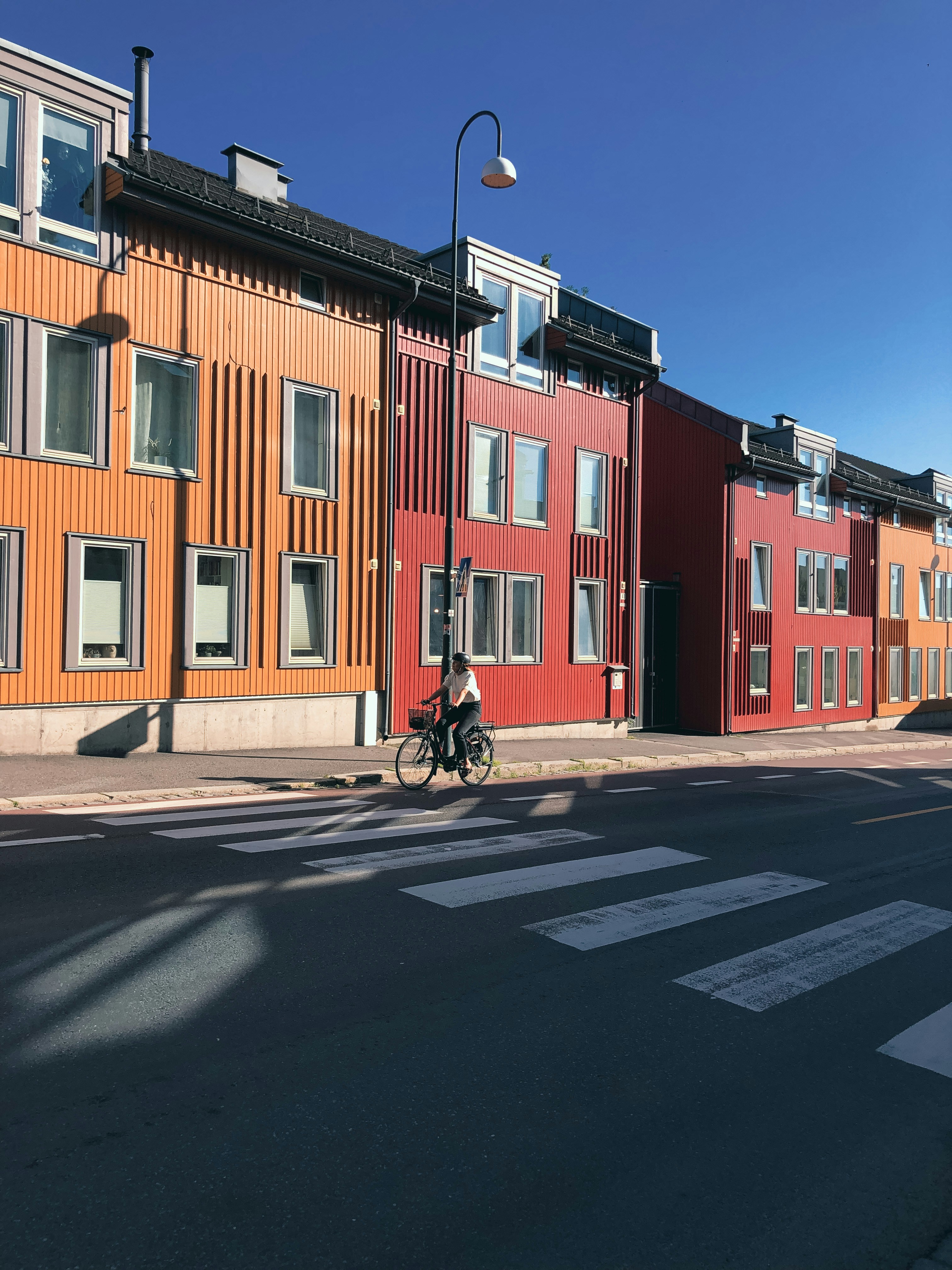 Brightly colored buildings and a cyclist on the street.