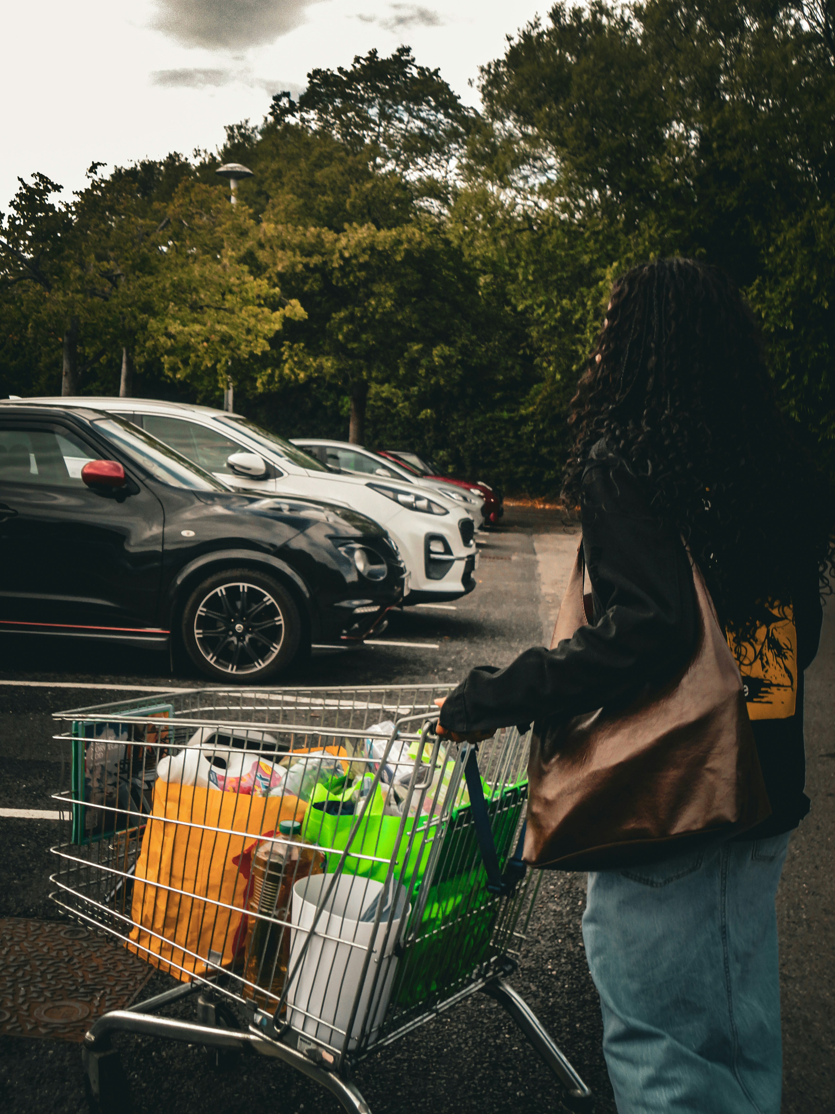 Woman pushes a shopping cart full of groceries.