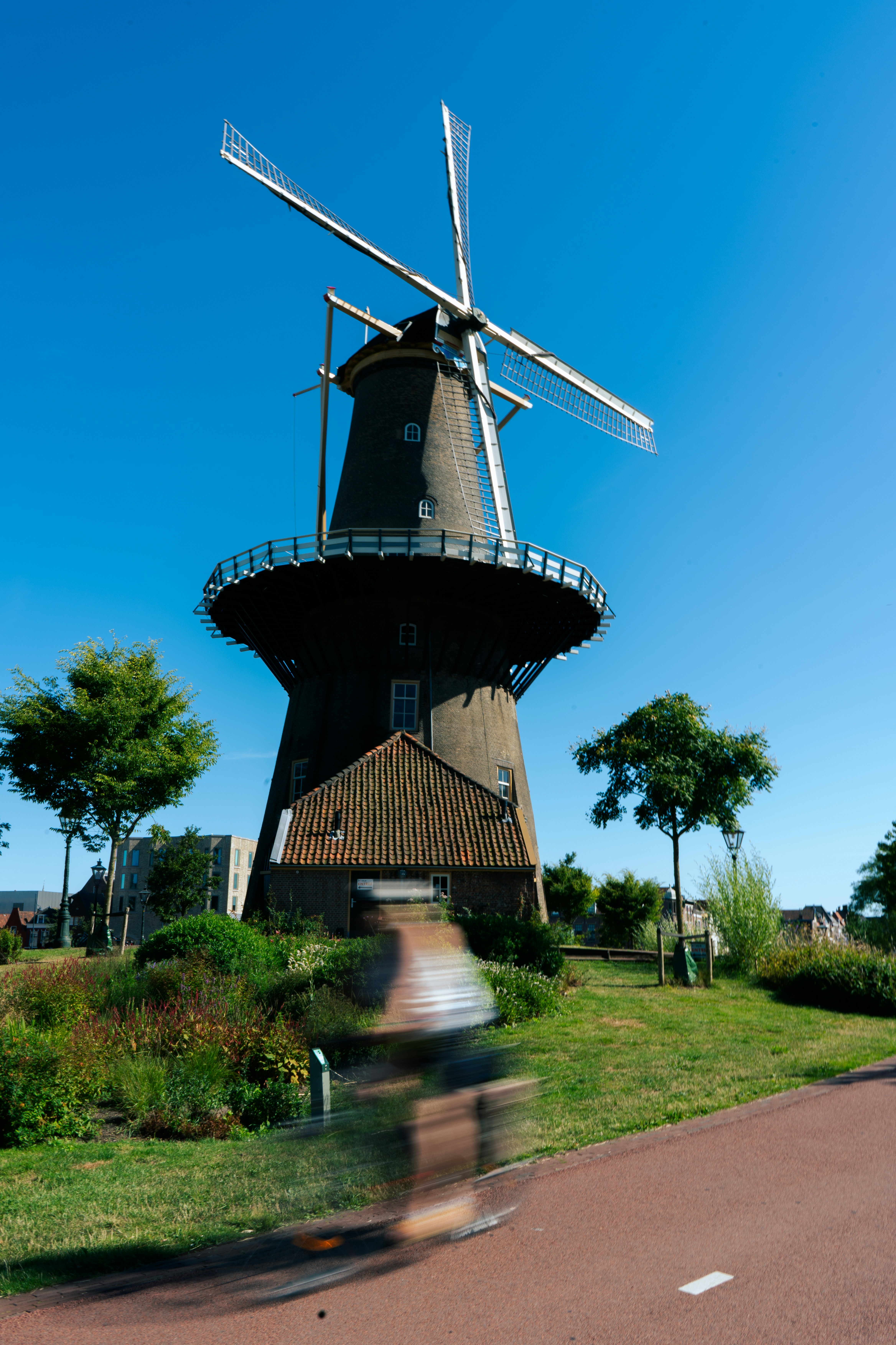 Dutch windmill with biker | A windmill stands tall over the landscape.