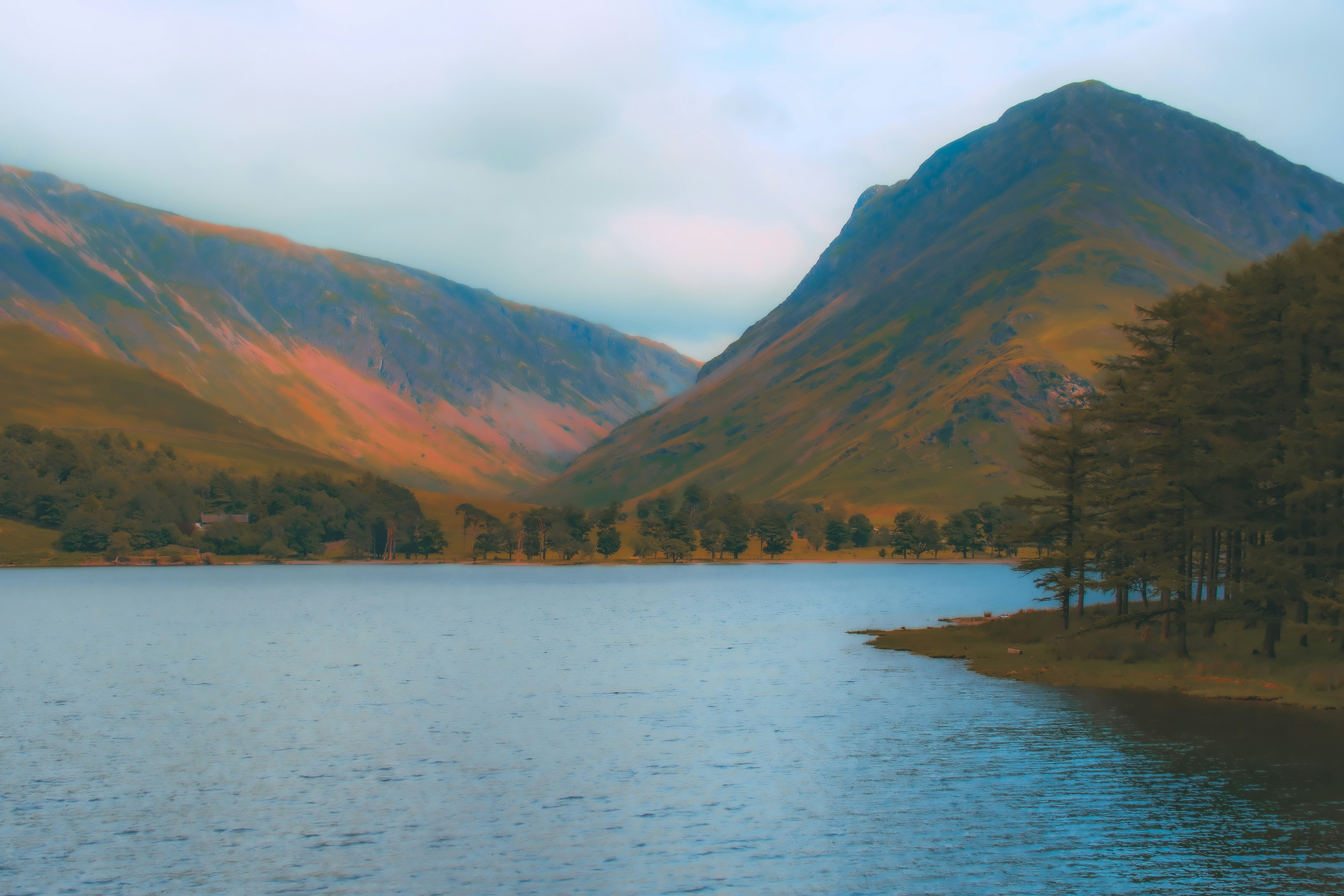 Lake and mountains under a cloudy sky.