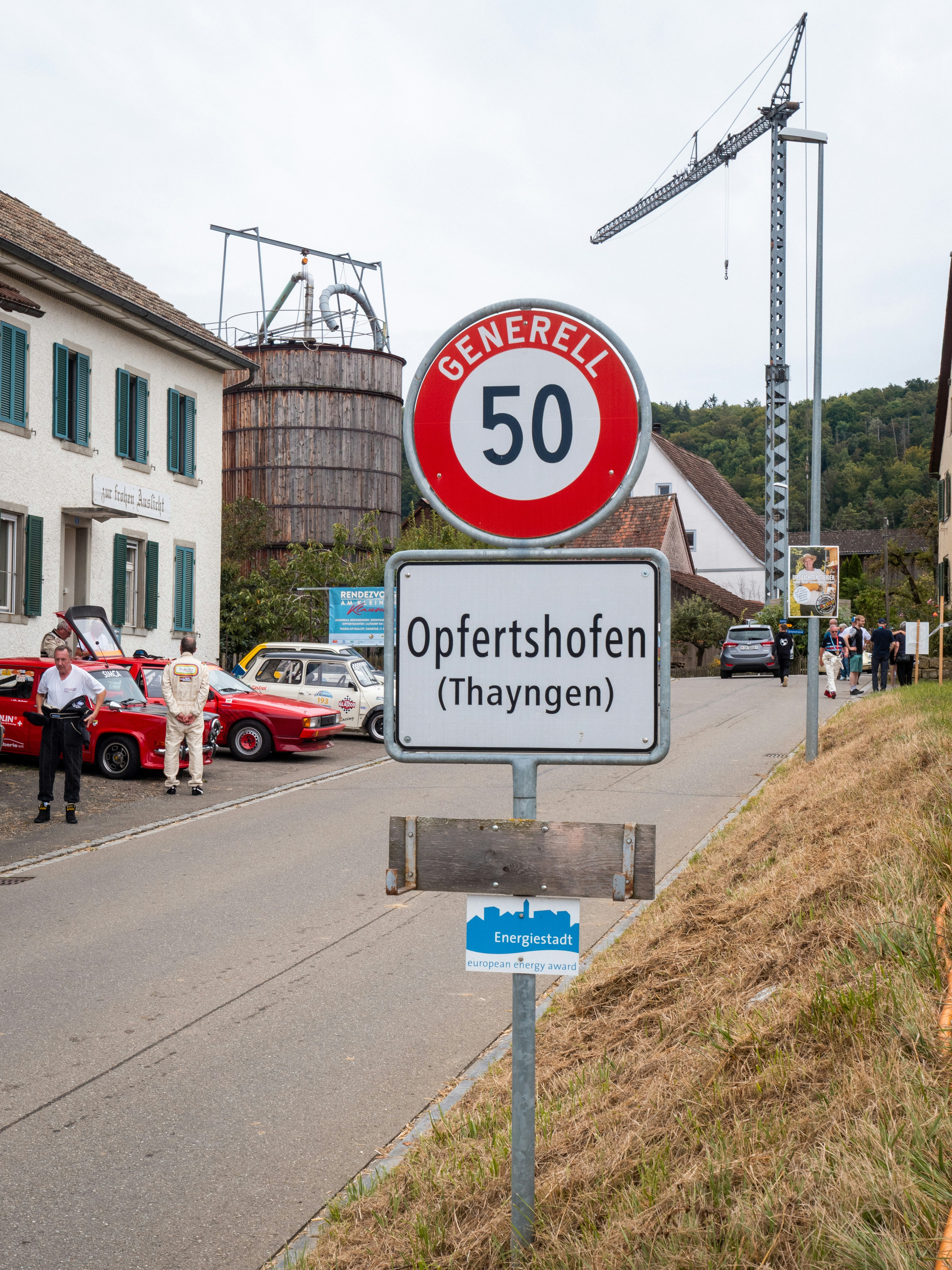 A street scene with signs and parked cars.