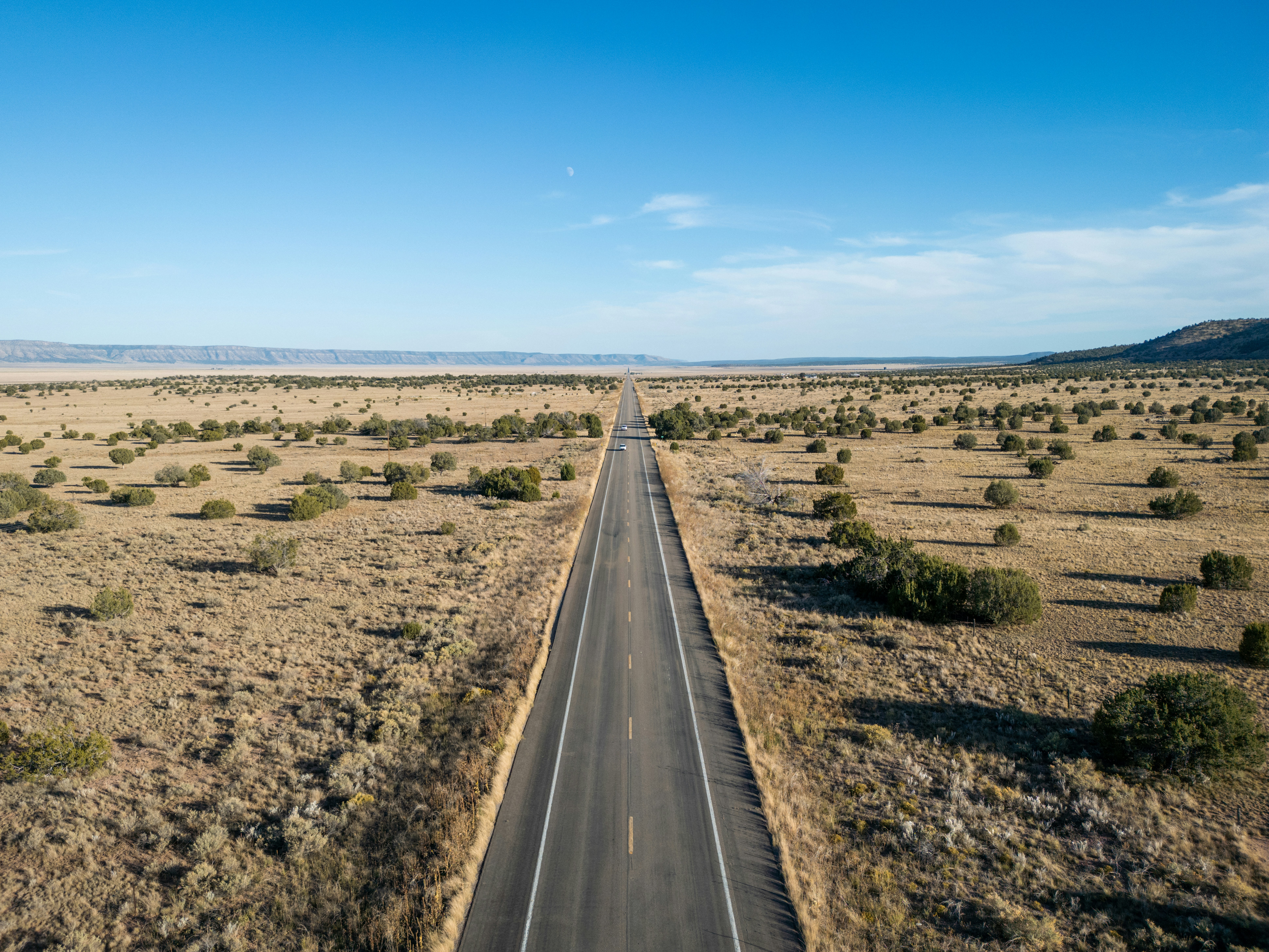 An empty road stretches through a dry landscape.