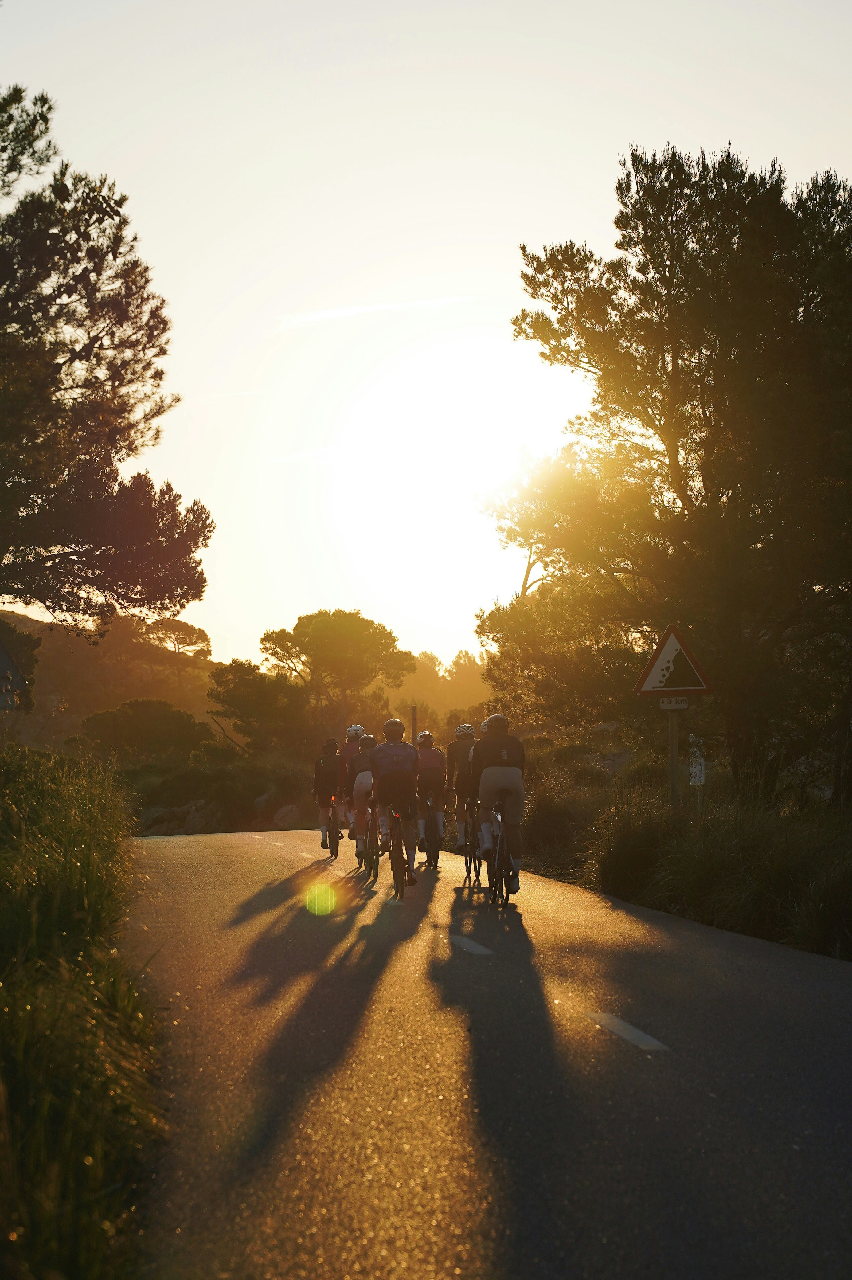 Processed with VSCO with k2 preset | Cyclists ride into the sunset on a scenic road.