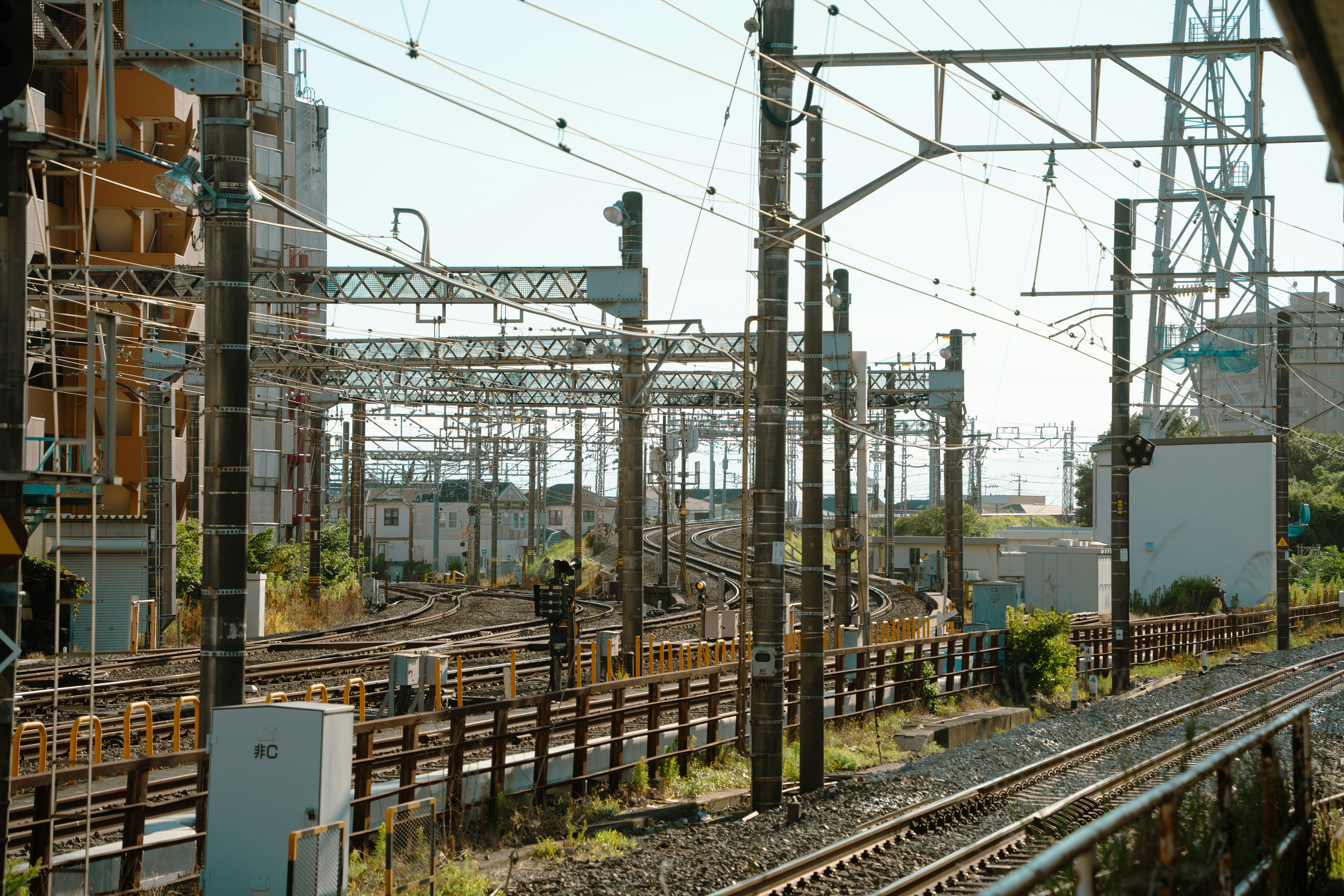 Train tracks, overhead wires, and urban buildings.