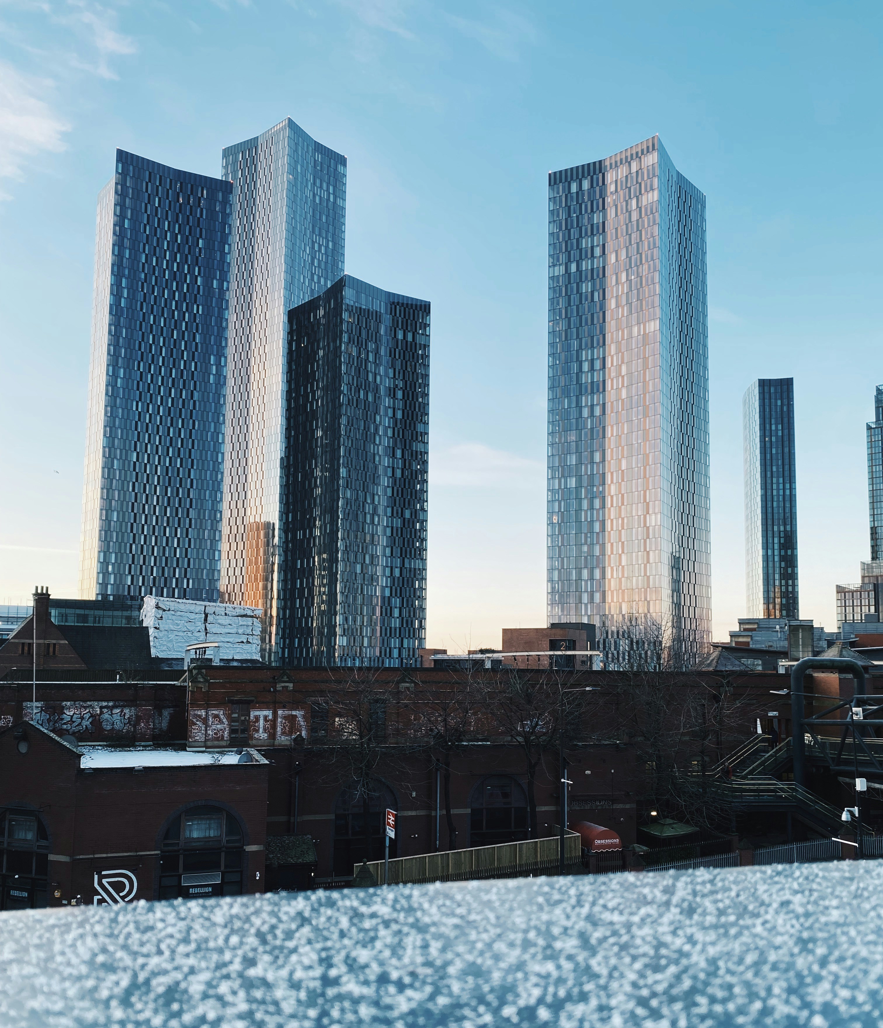 Skyscrapers stand tall against a clear blue sky.