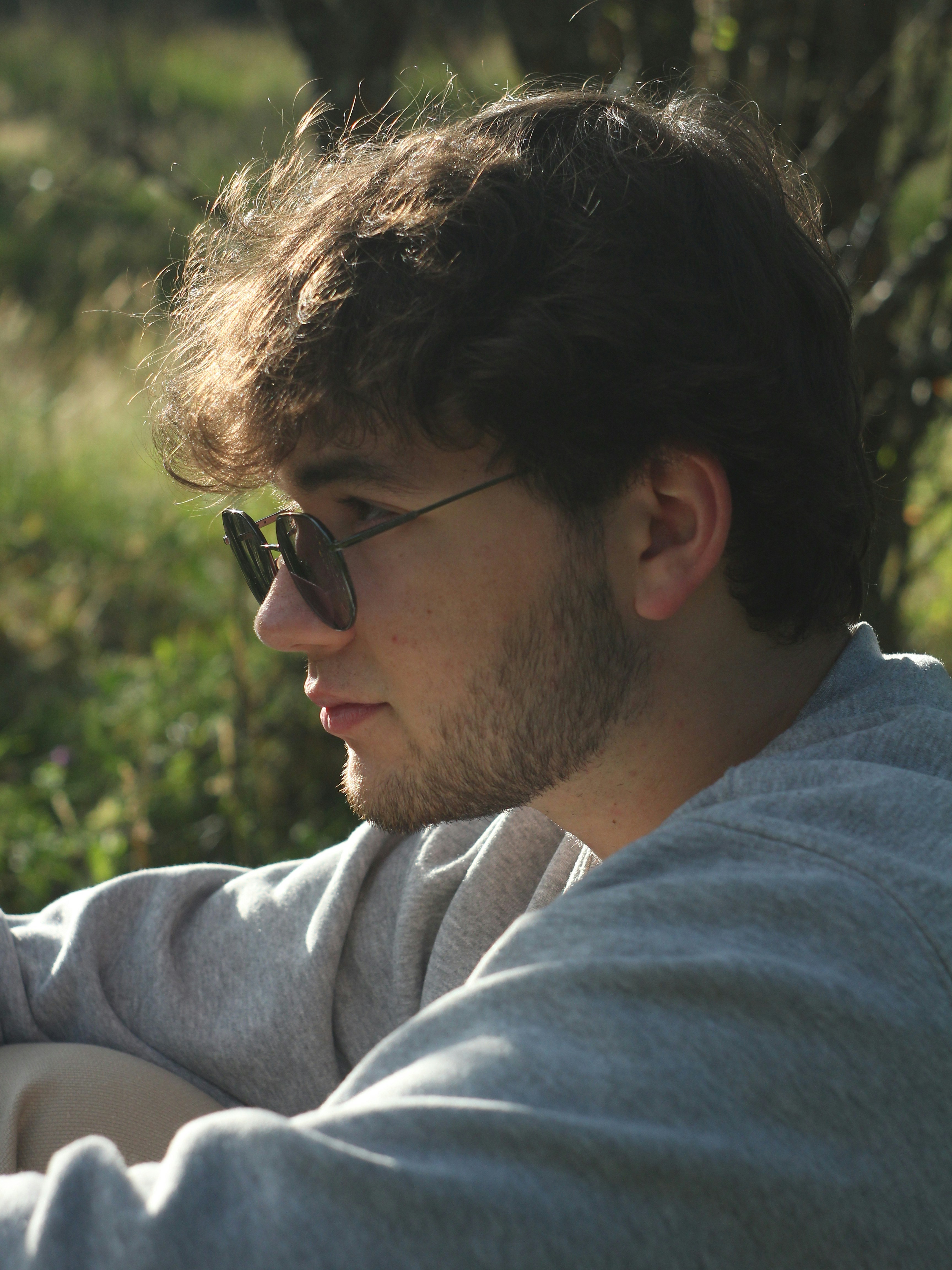 A young man wears sunglasses outdoors.