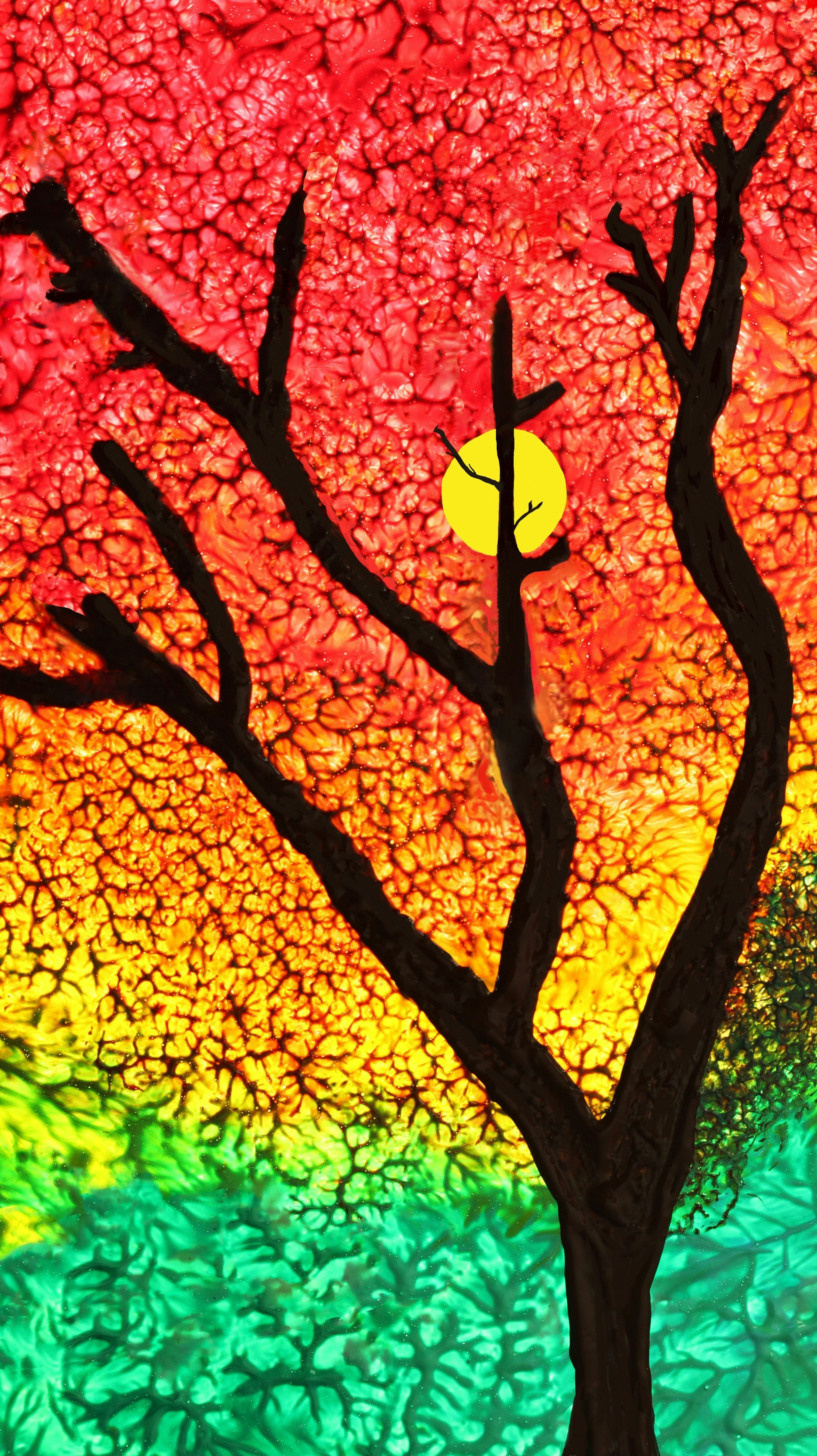 Tree silhouetted against a colorful sunset.