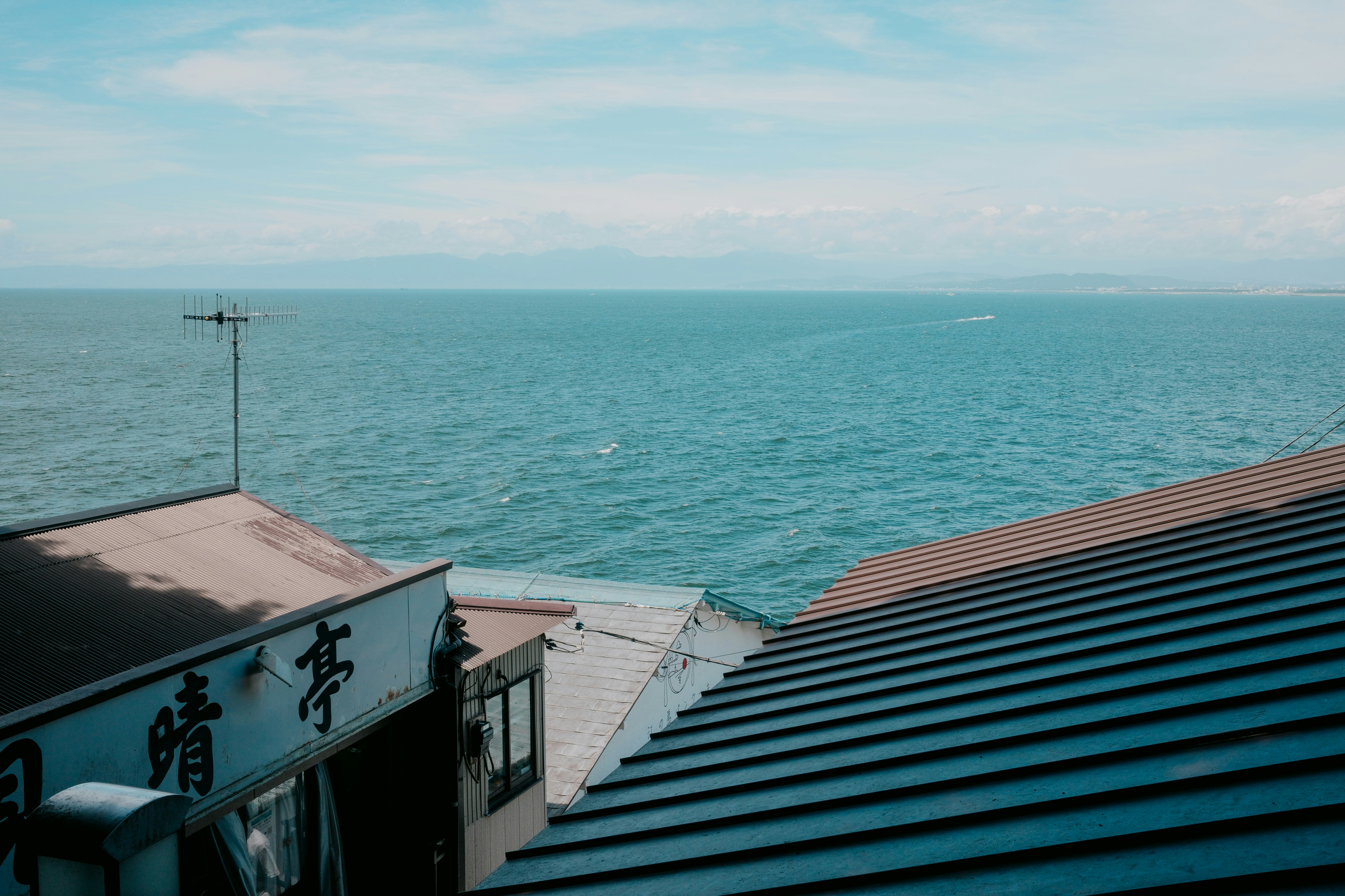 Rooftop Blue: Quiet Vista Where Roof Tiles Meet the Open Sea