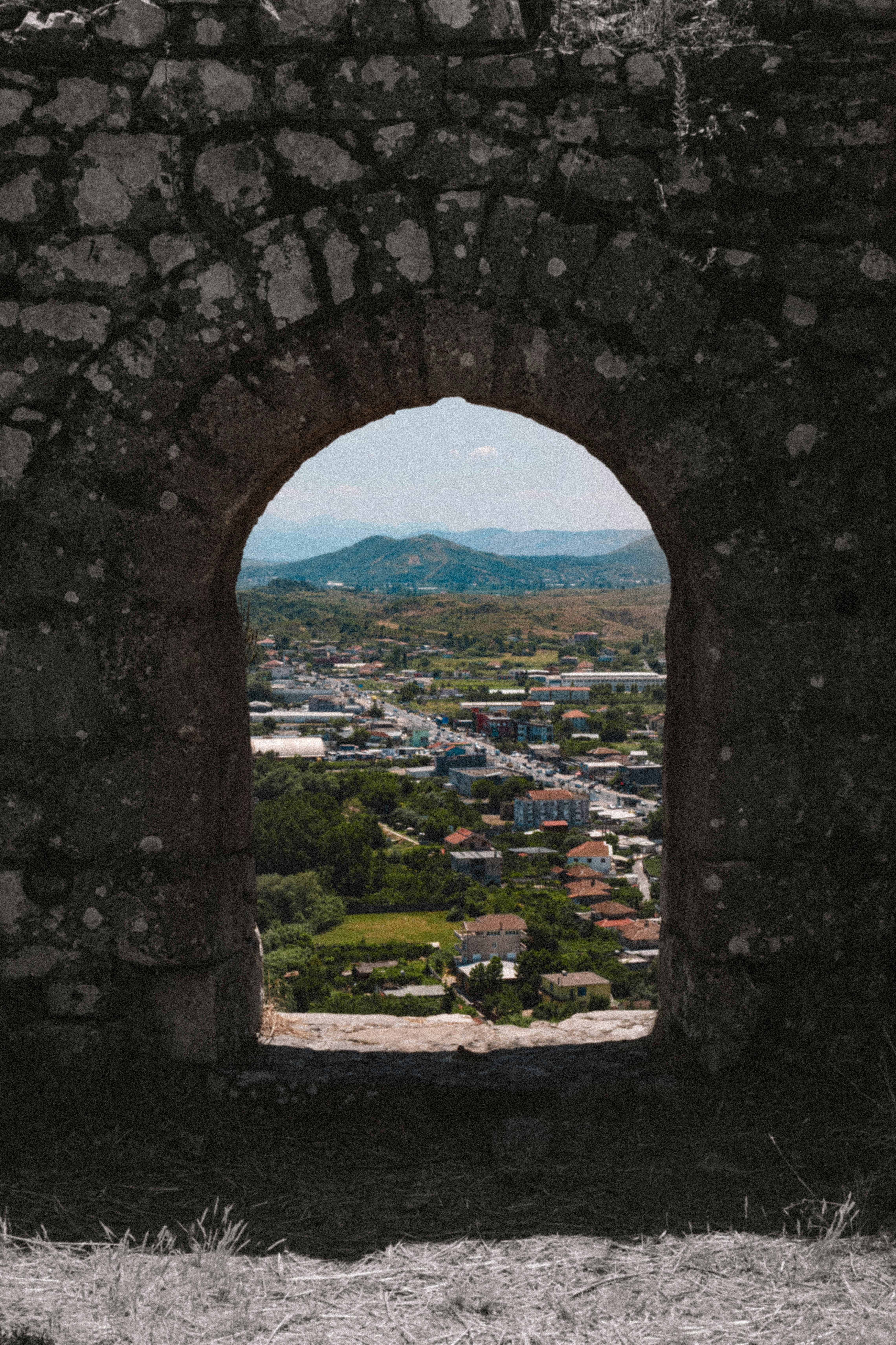 View through a stone archway of a town.