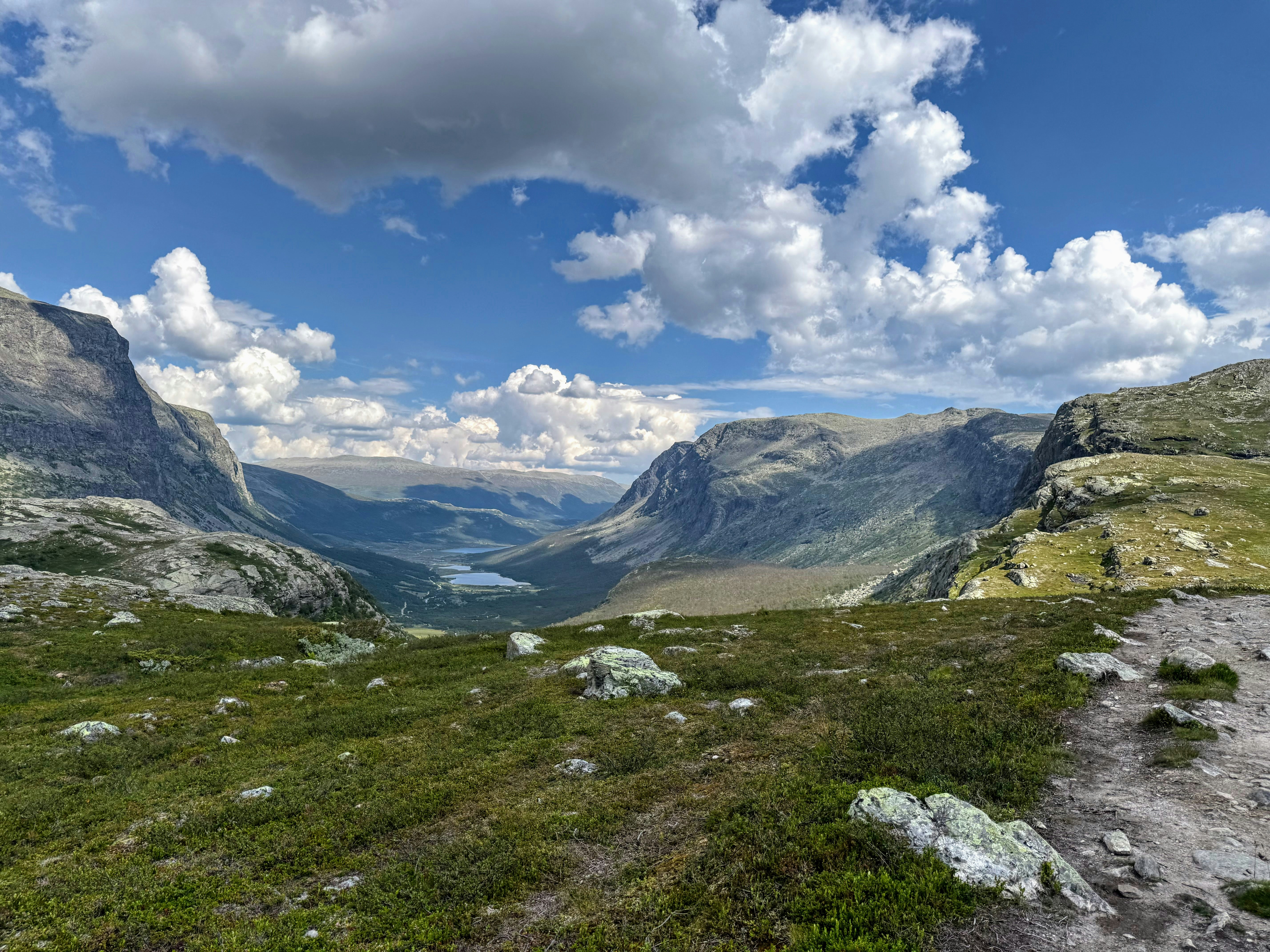 Mountains and a lake under a beautiful, cloudy sky.