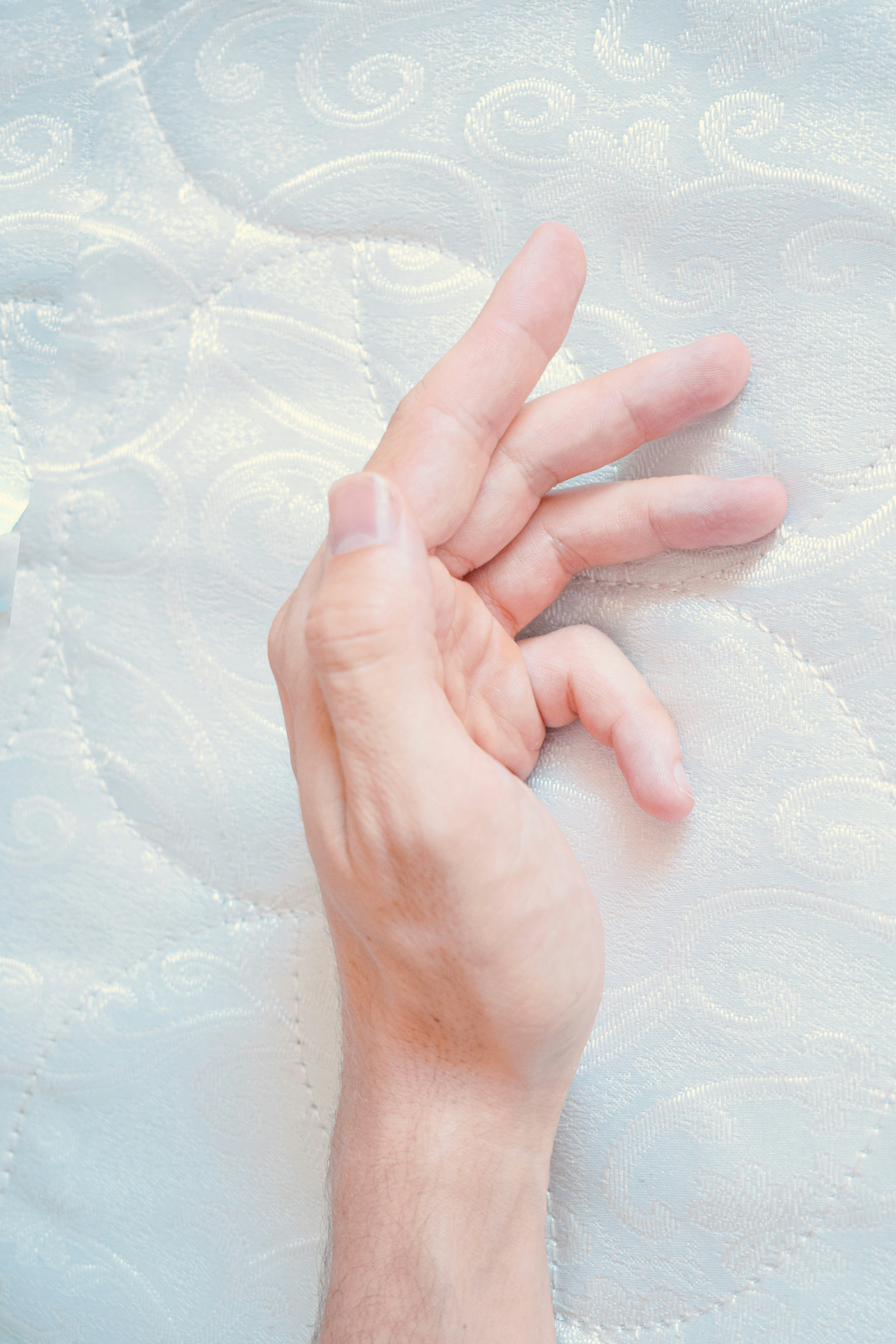 Hand forming a gesture on a patterned surface.