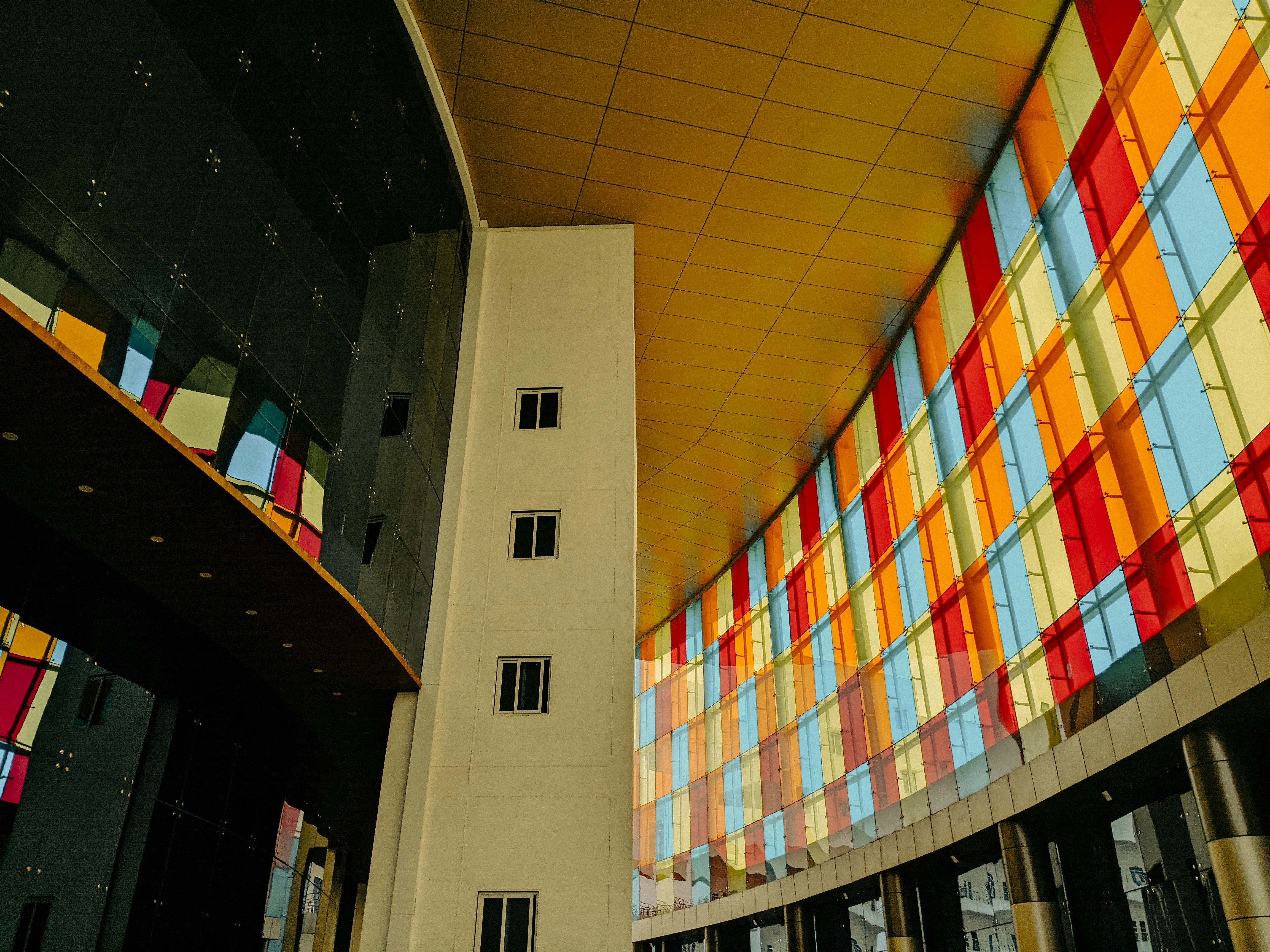 Almost Opaque tinted glass wall with soft light. | Colorful windows brighten the interior of the building.