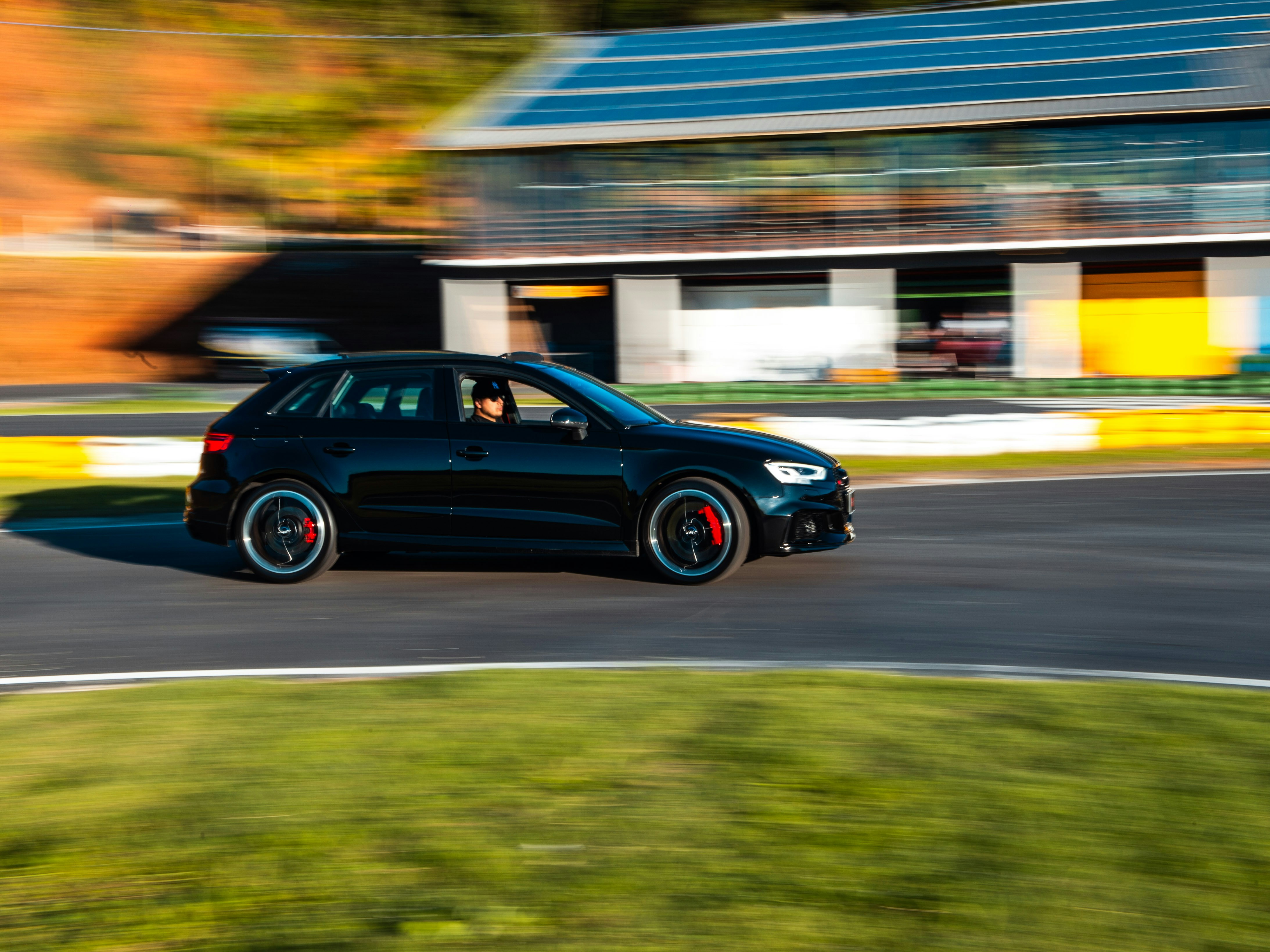 A black car speeds around a racetrack.