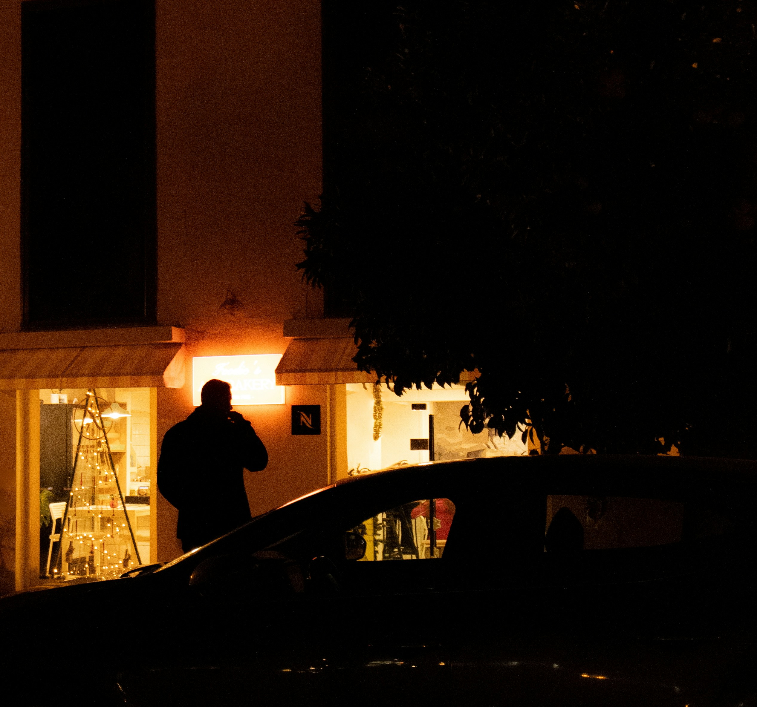 Tired days | A person stands outside a building at night.