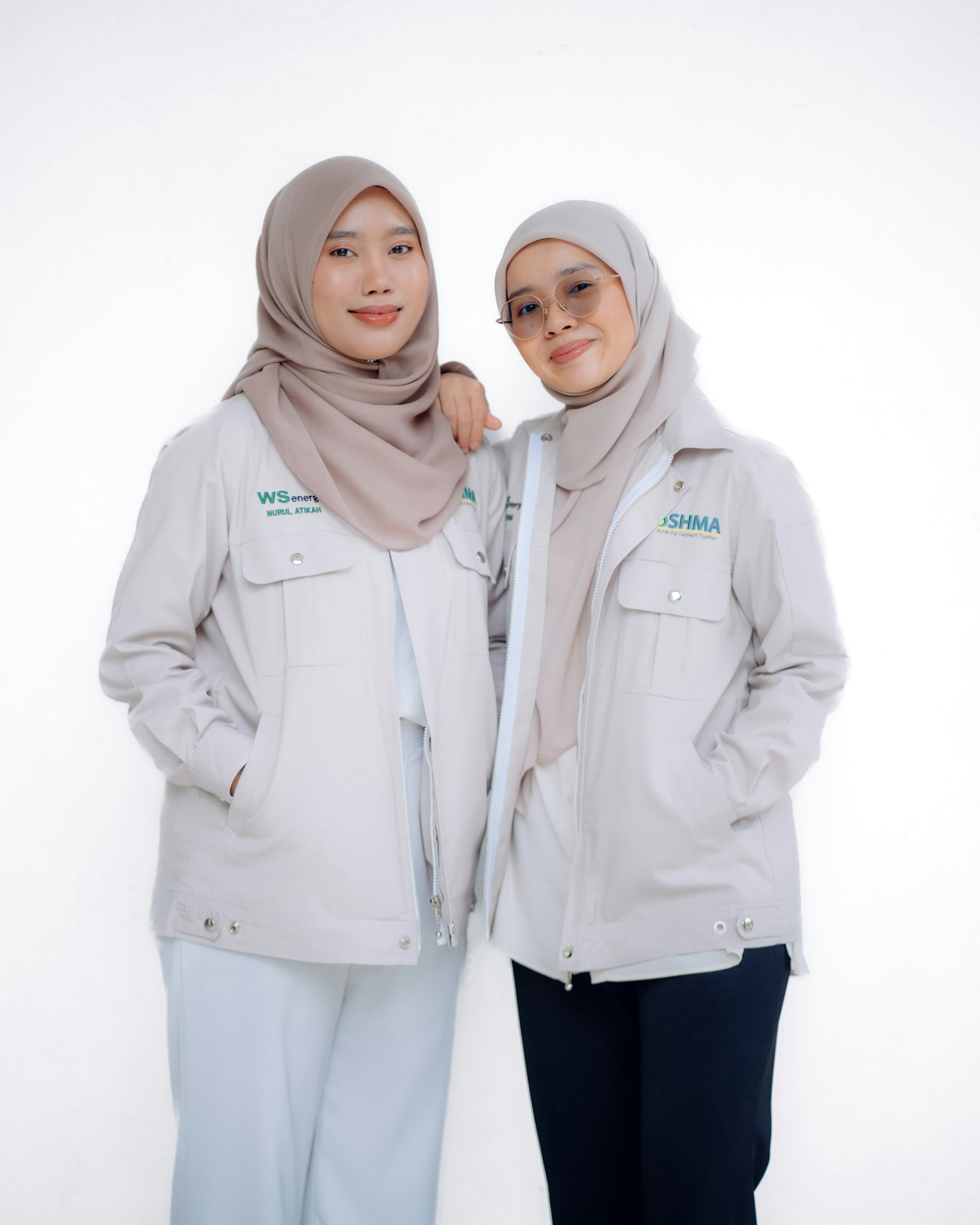 Two women pose for a photo wearing jackets.