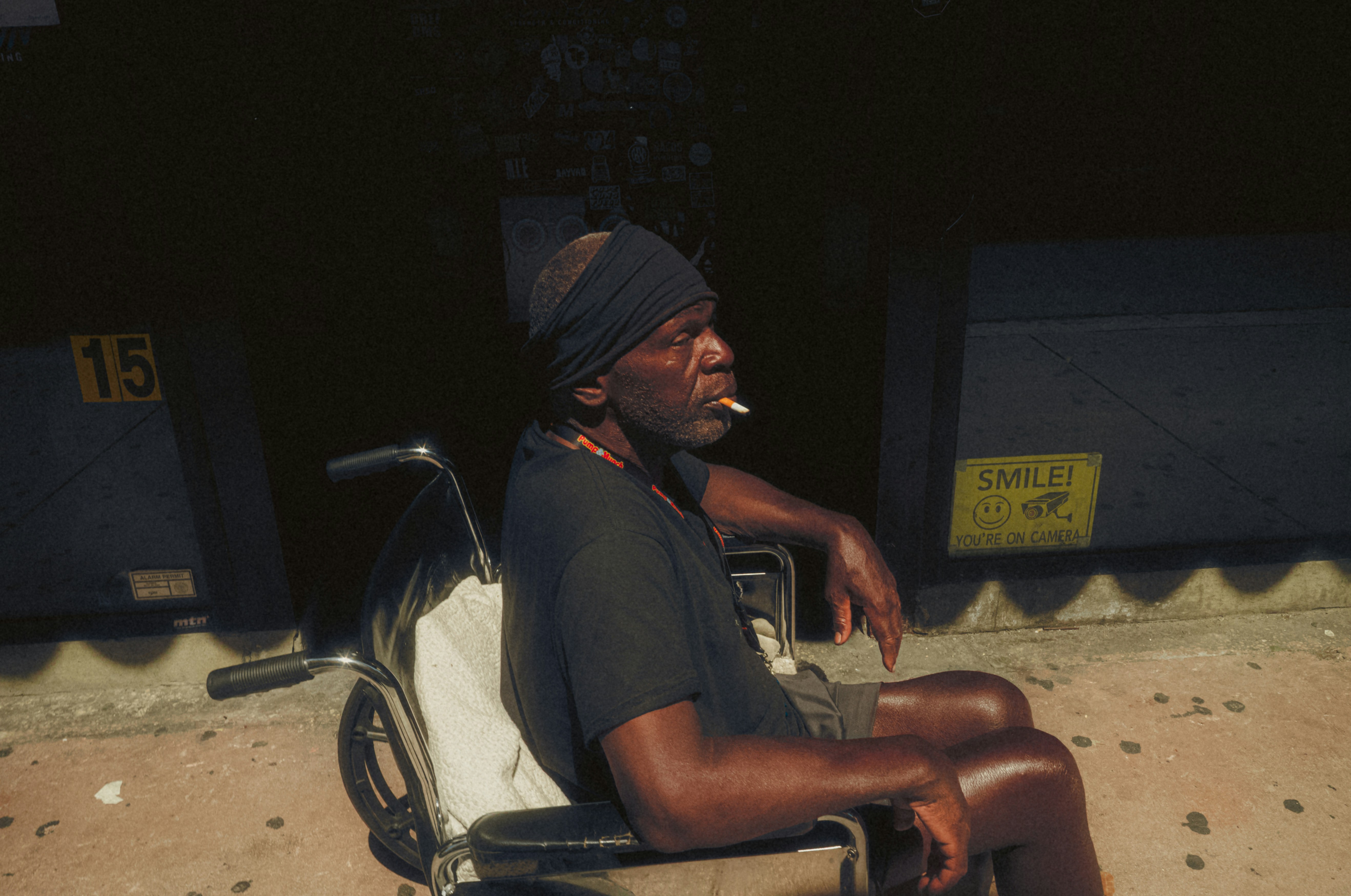 Man in wheelchair smokes a cigarette.