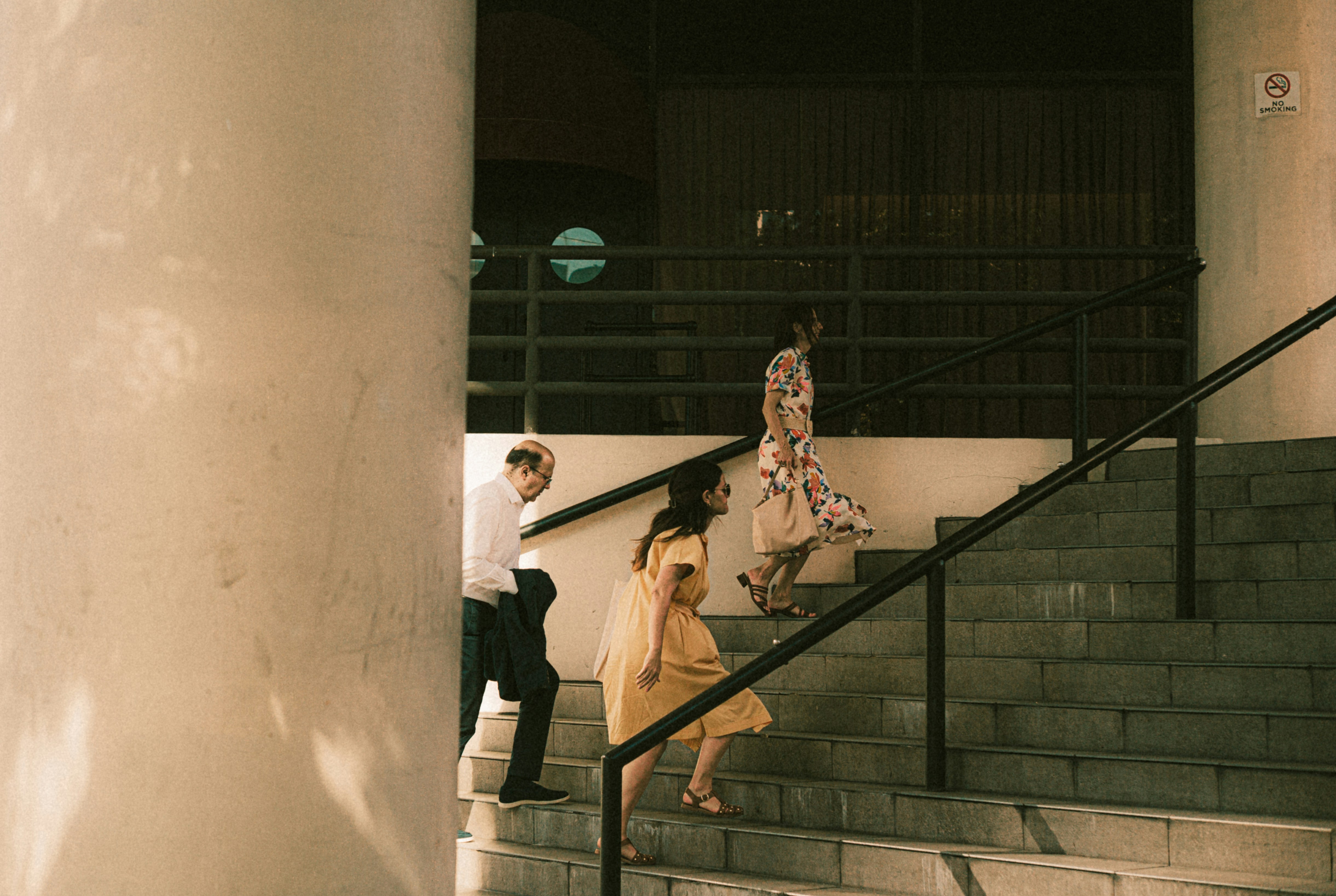 People walk up a flight of outdoor stairs.