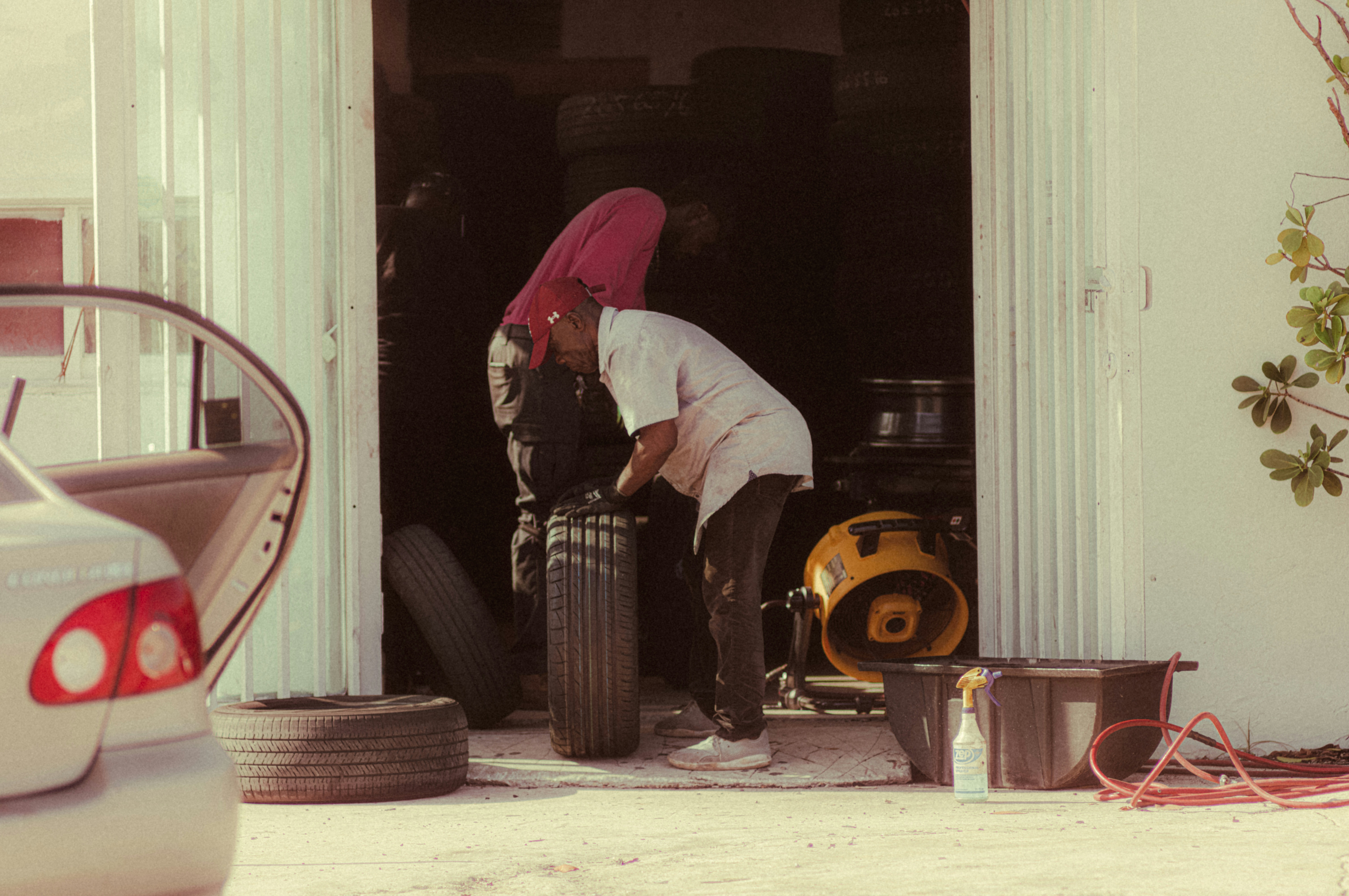 Mechanic fixing a car tire inside a garage.