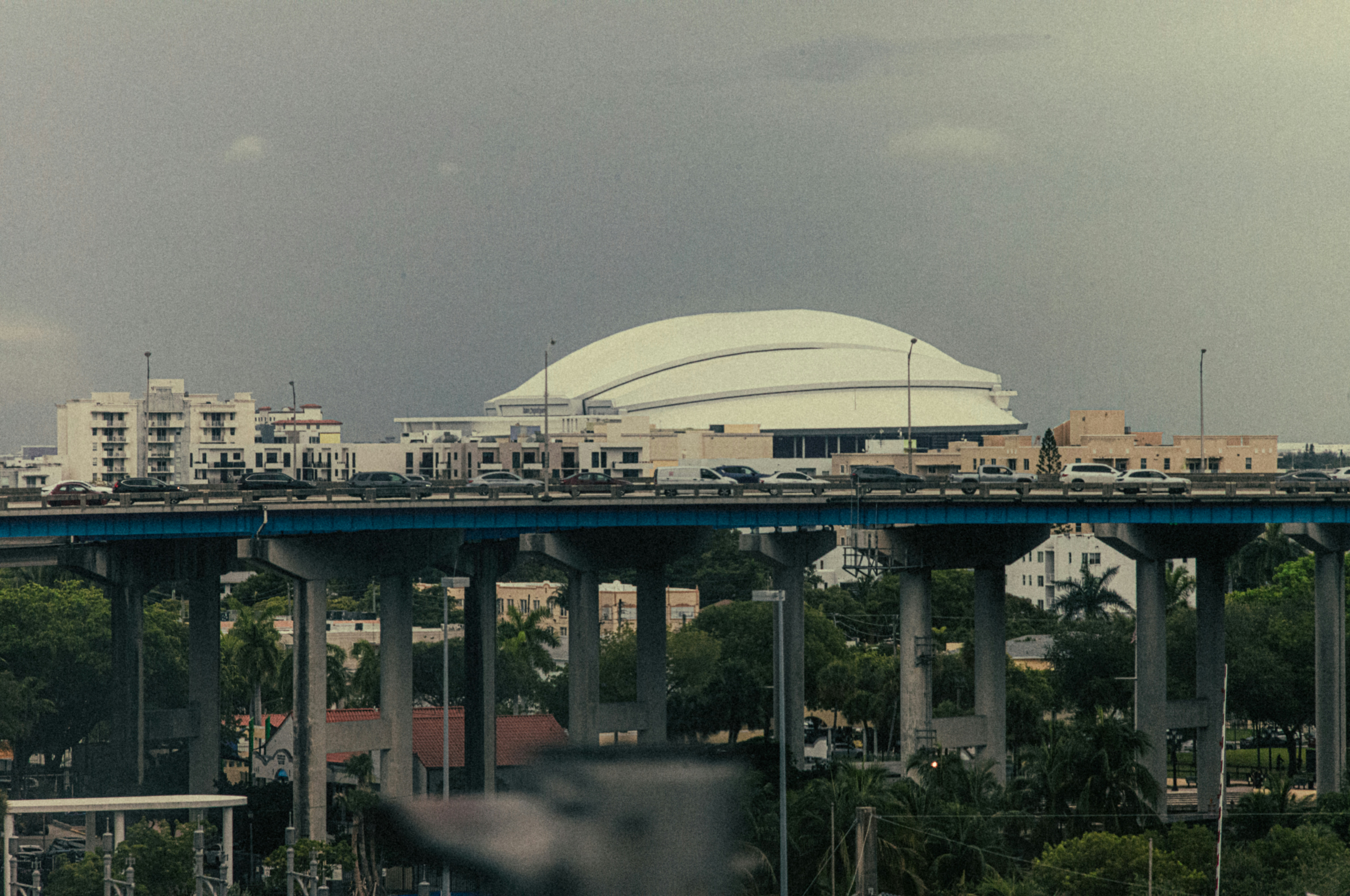 An elevated highway passes by a large stadium.