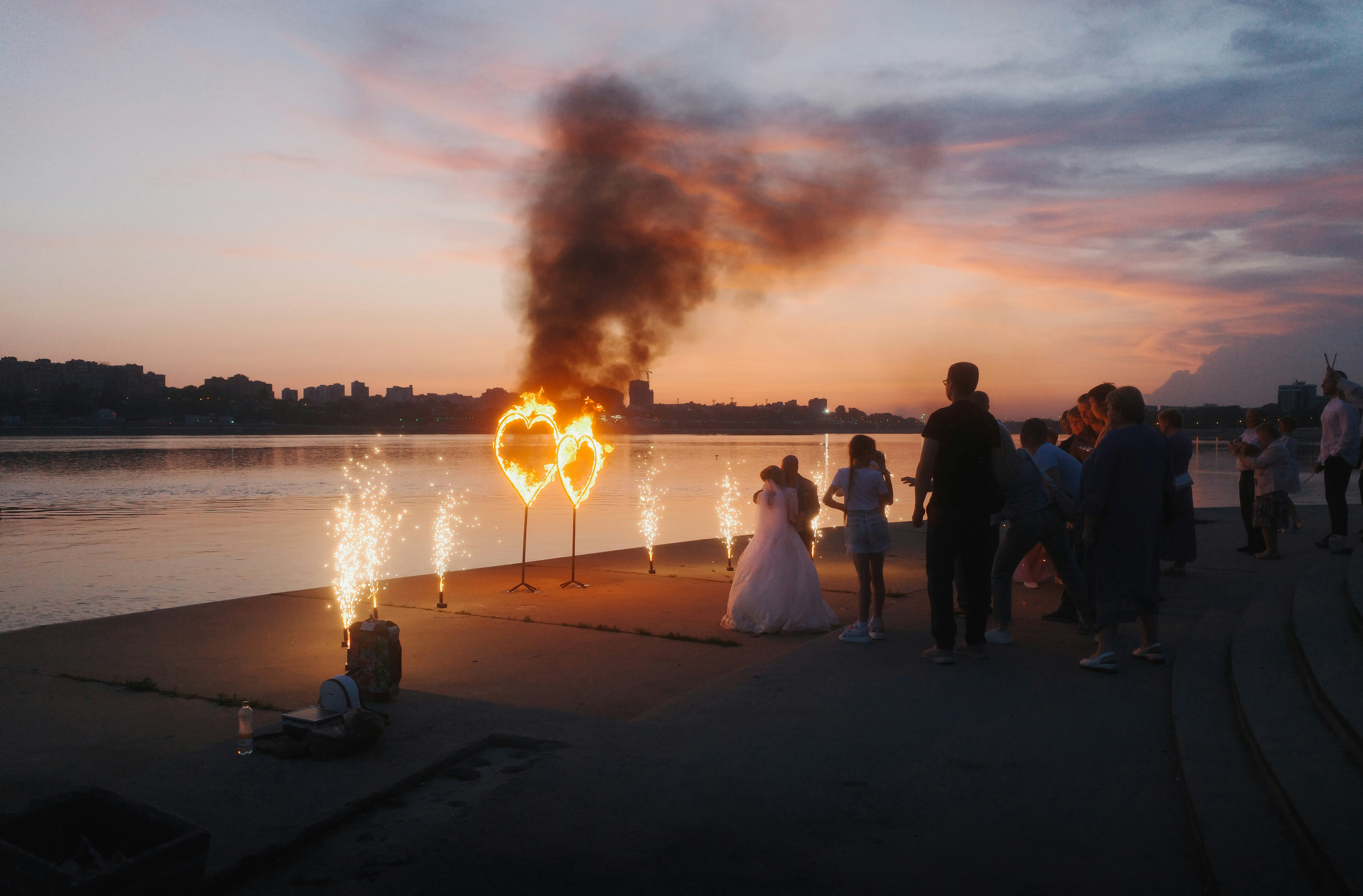 Fire and people watch a riverside sunset. photo – Free Sunset Image on ...