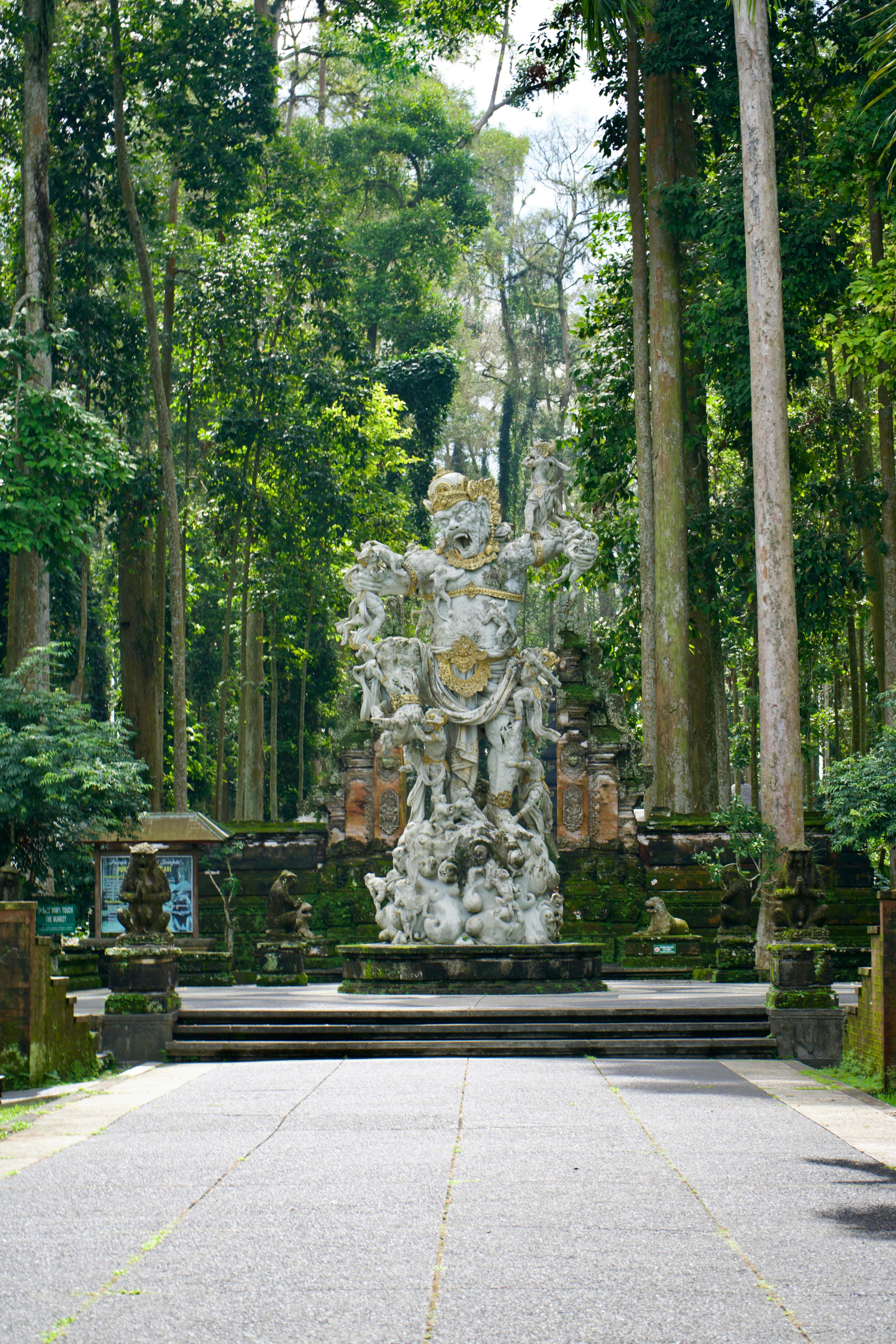 Bali monkey forest | A large statue stands in a lush forest.