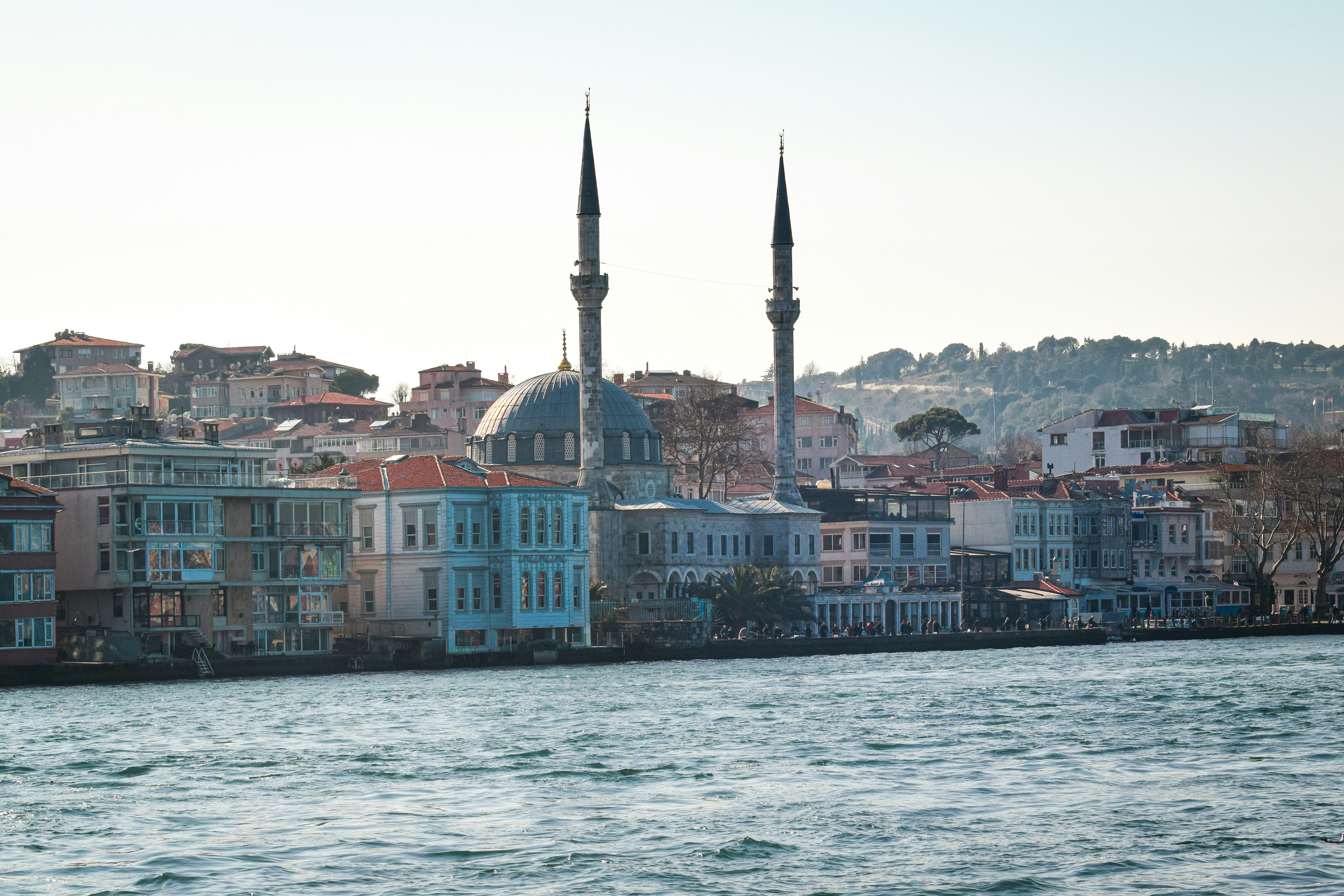 Bosphorus waterfront in Istanbul. | A mosque sits near buildings on the water.