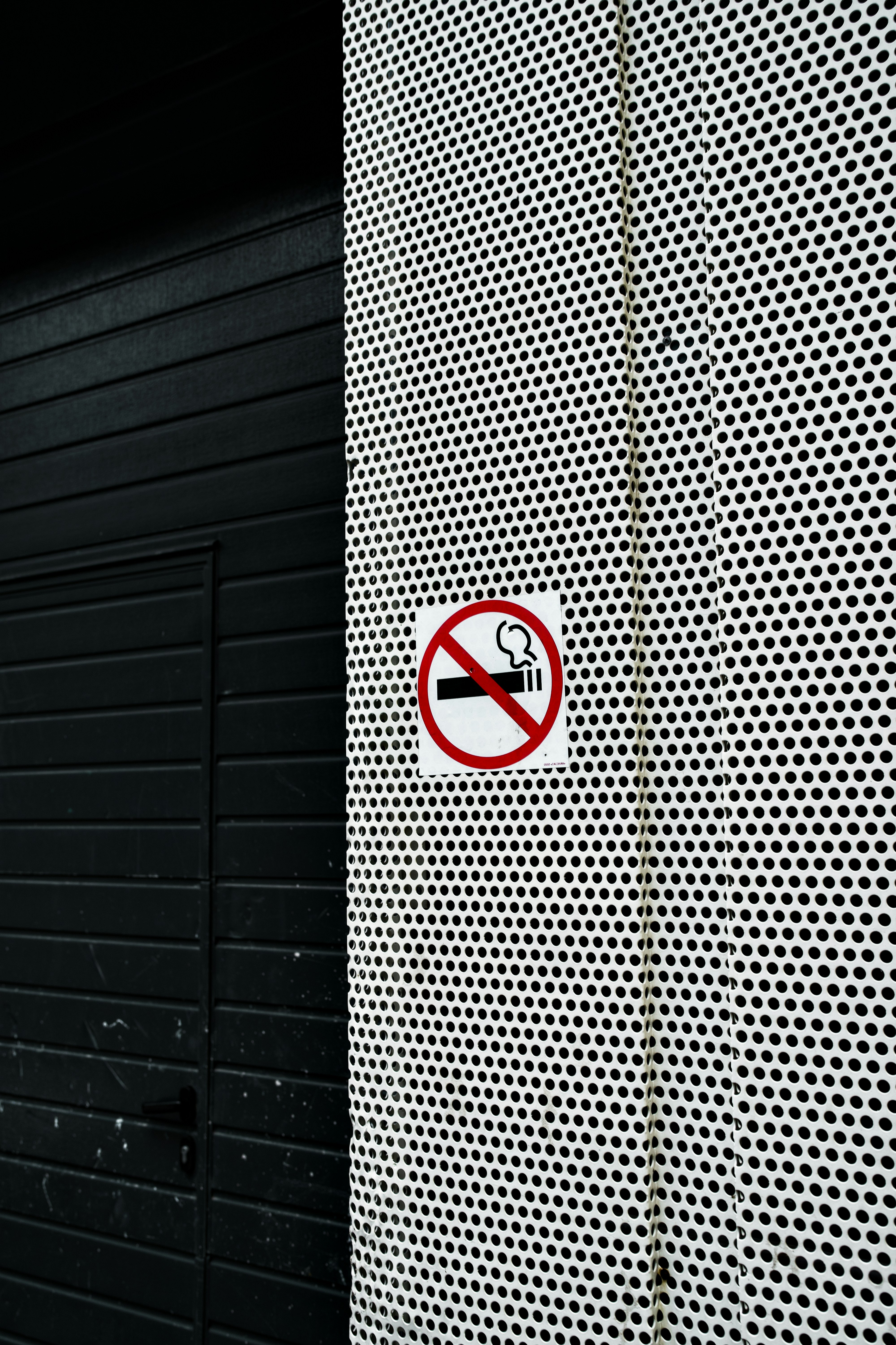 Perforated Steel Portrait with a No-Smoking Sign: A Close-Up on Industrial Texture