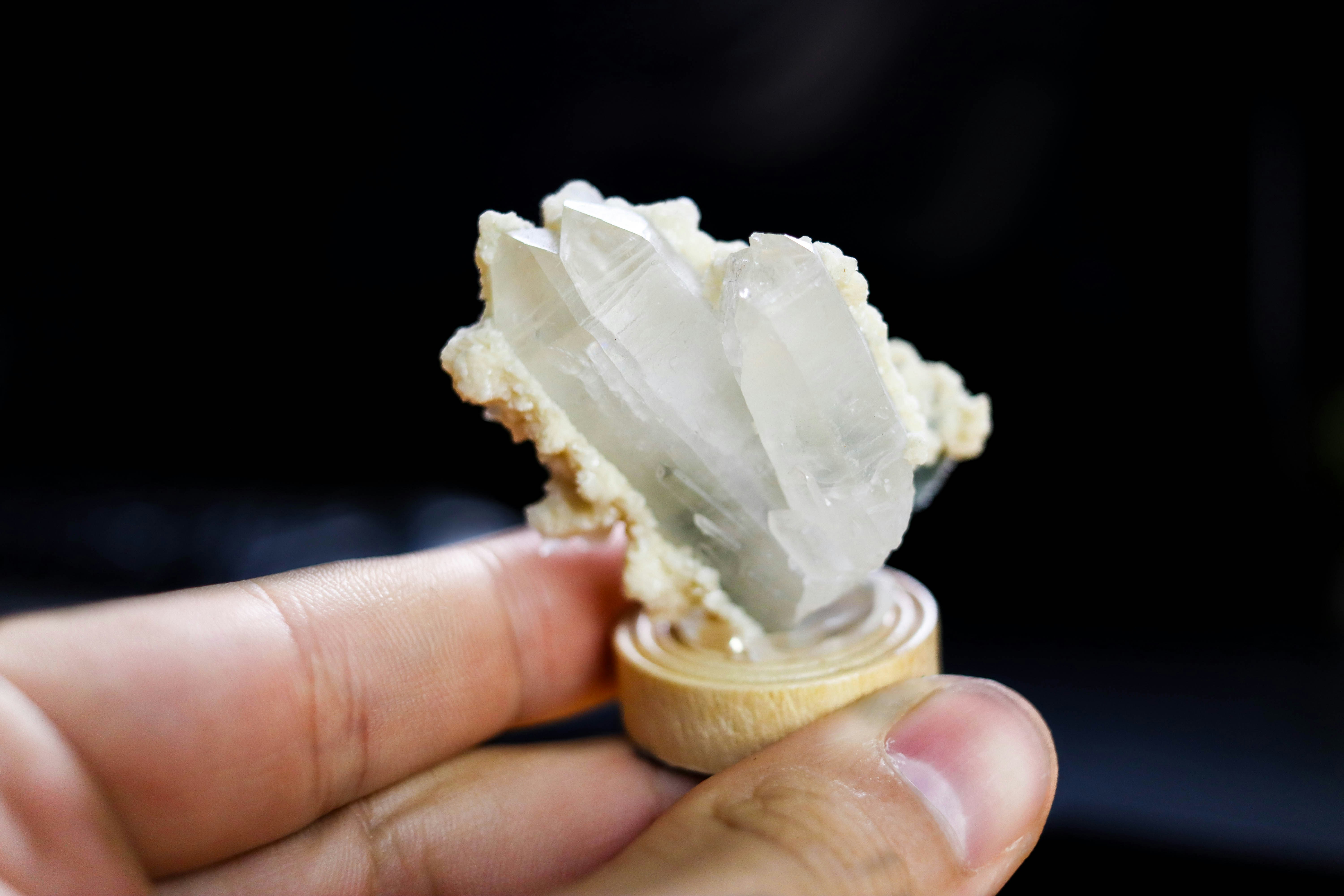 Here is a short caption: a person holds a piece of crystal.