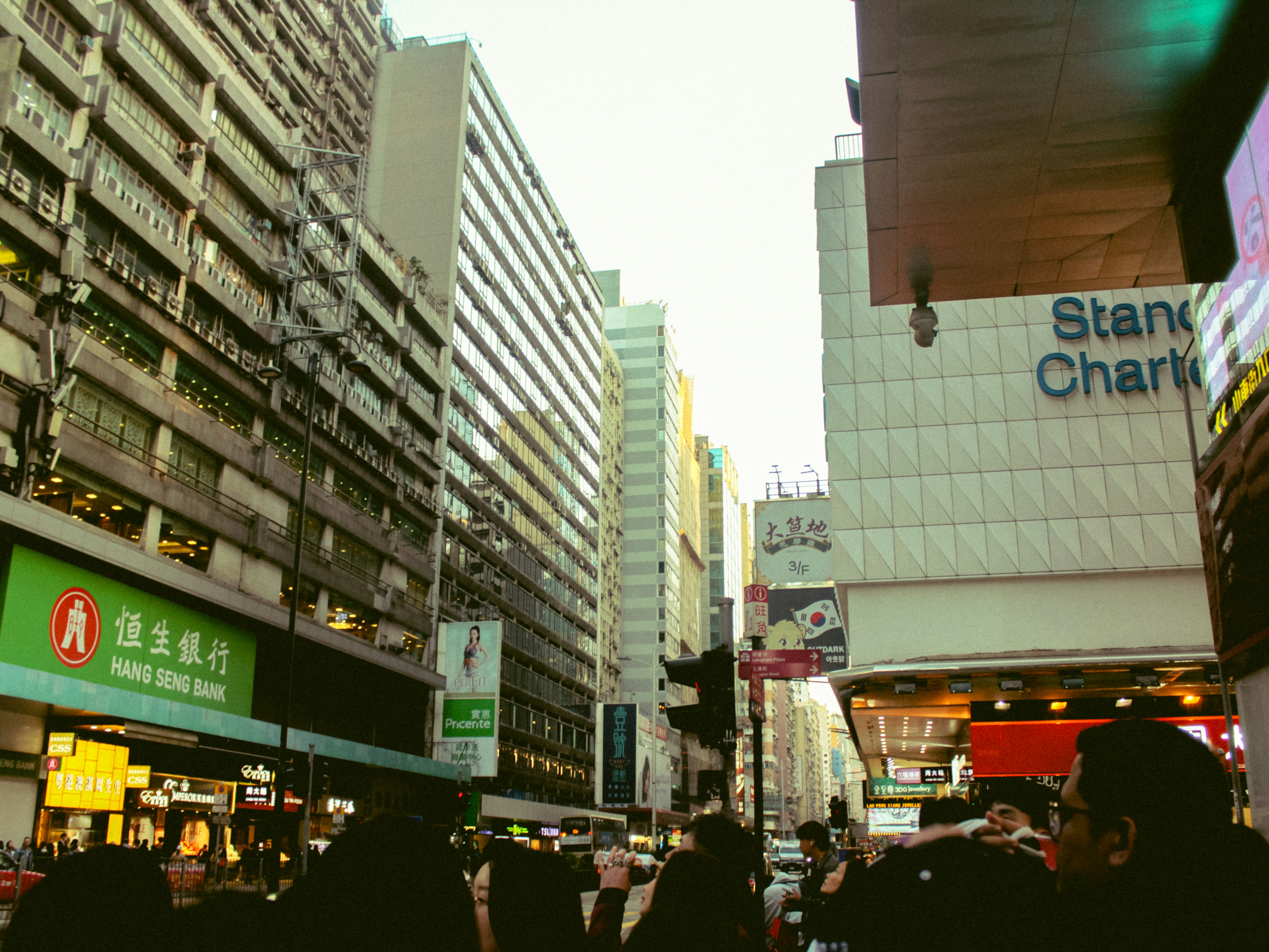 Urban scene with tall buildings and pedestrians.