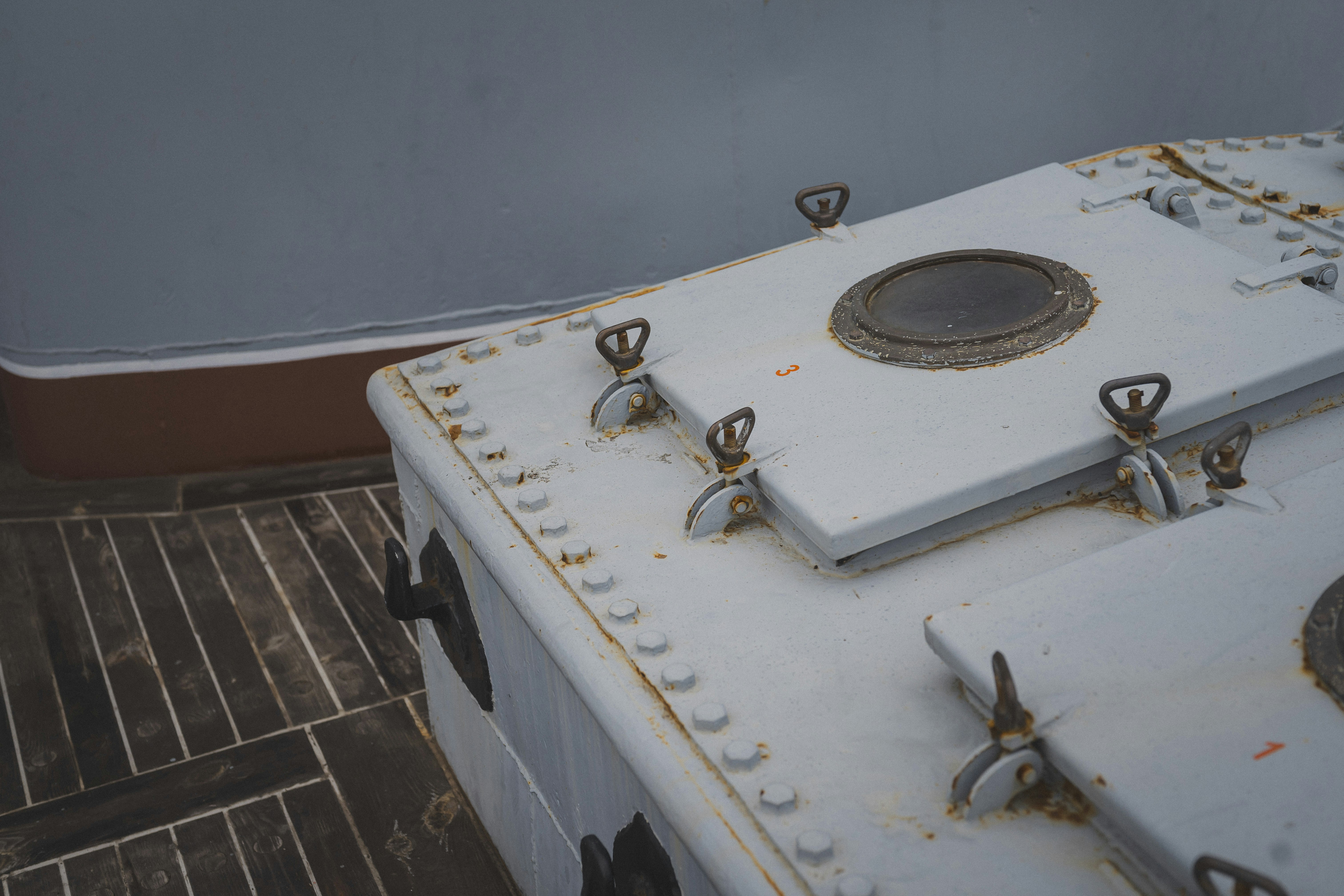 Details of the old Red Pennant (Красный Вымпел) naval vessel from Vladivostok | Metal hatches are seen on a ship's deck.