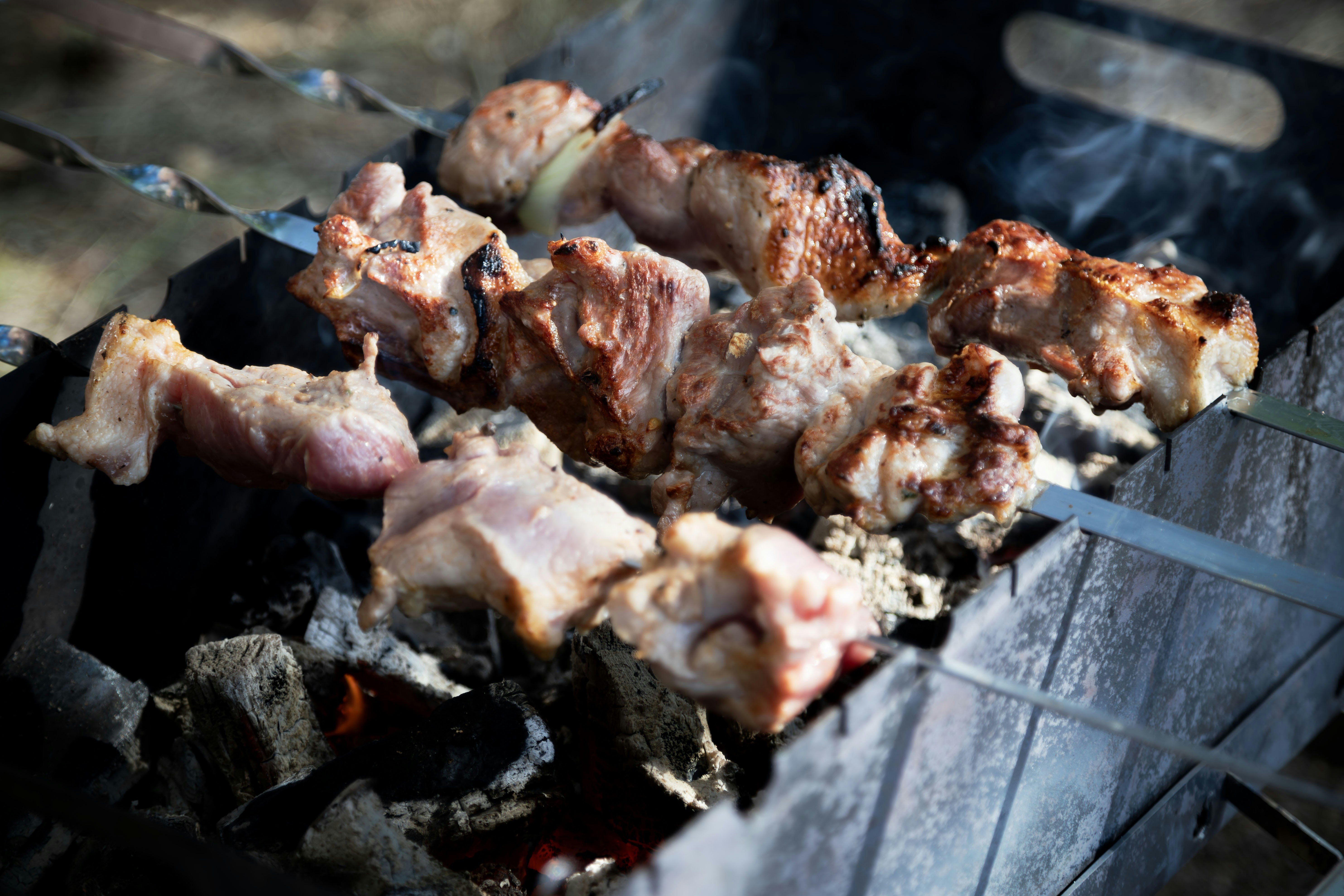 Meat skewers grilling over hot charcoal.