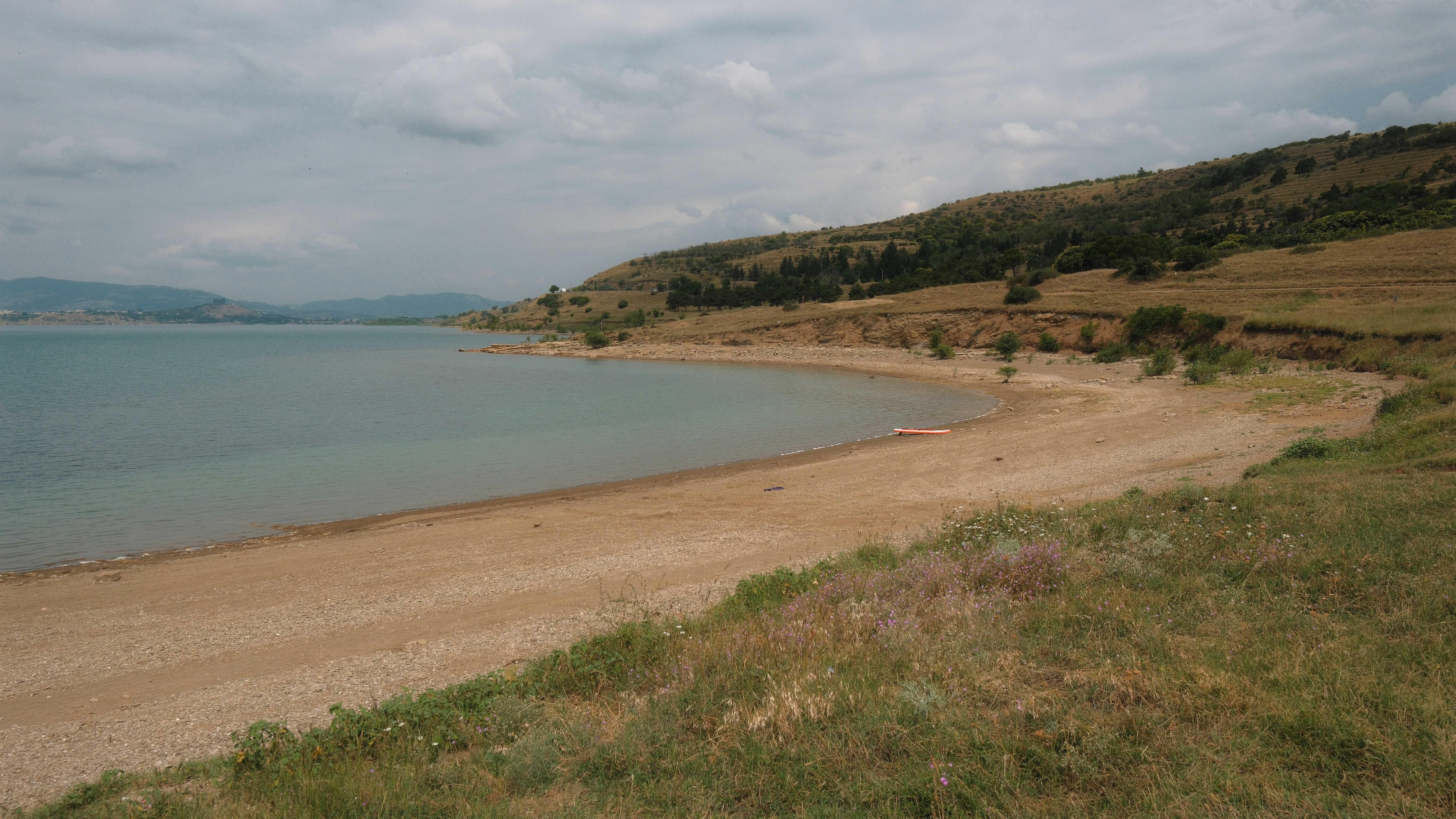 A sandy beach borders a beautiful lake.