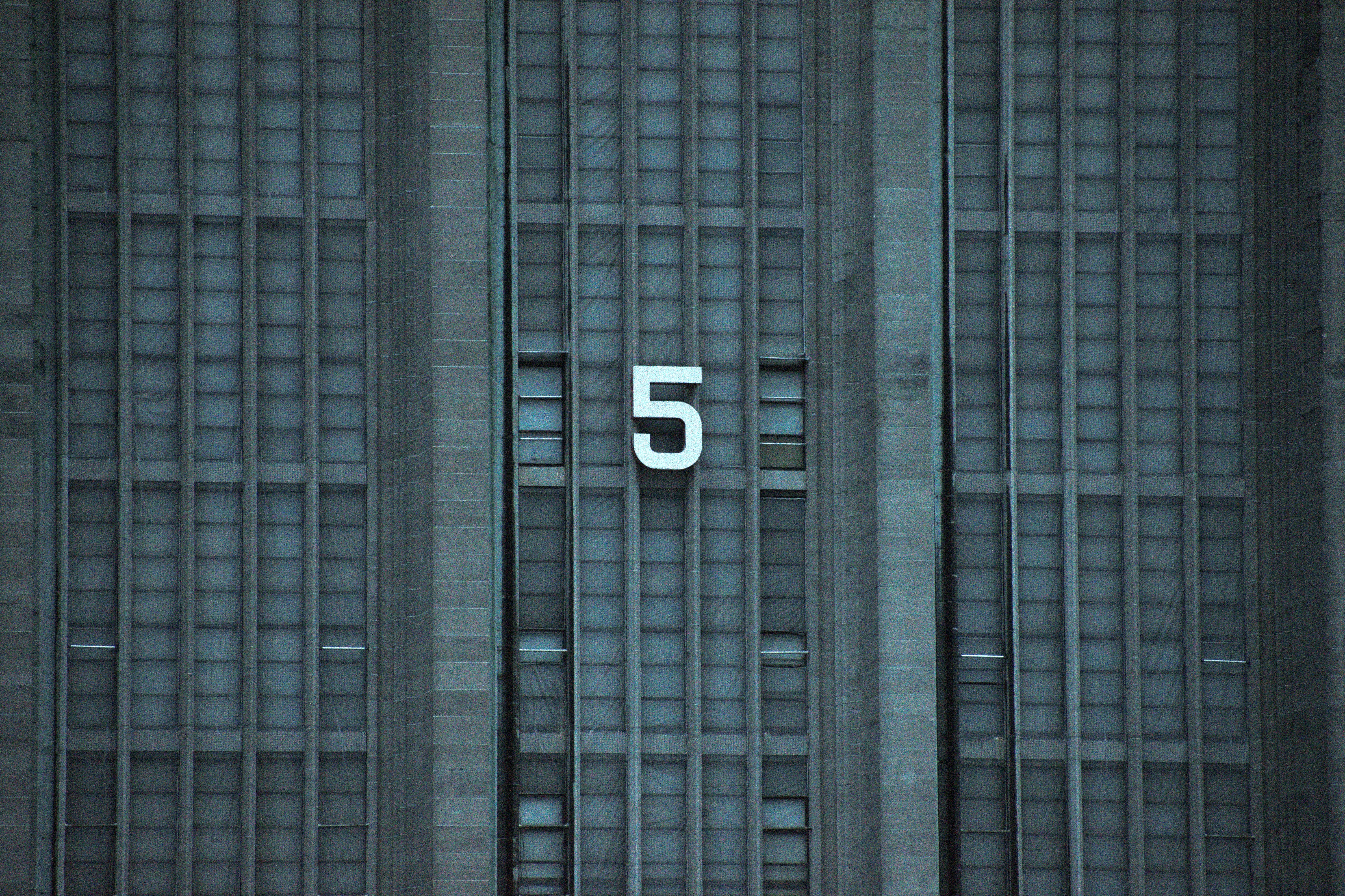Huge building with number 5 on it. | A wall has the number five on it.