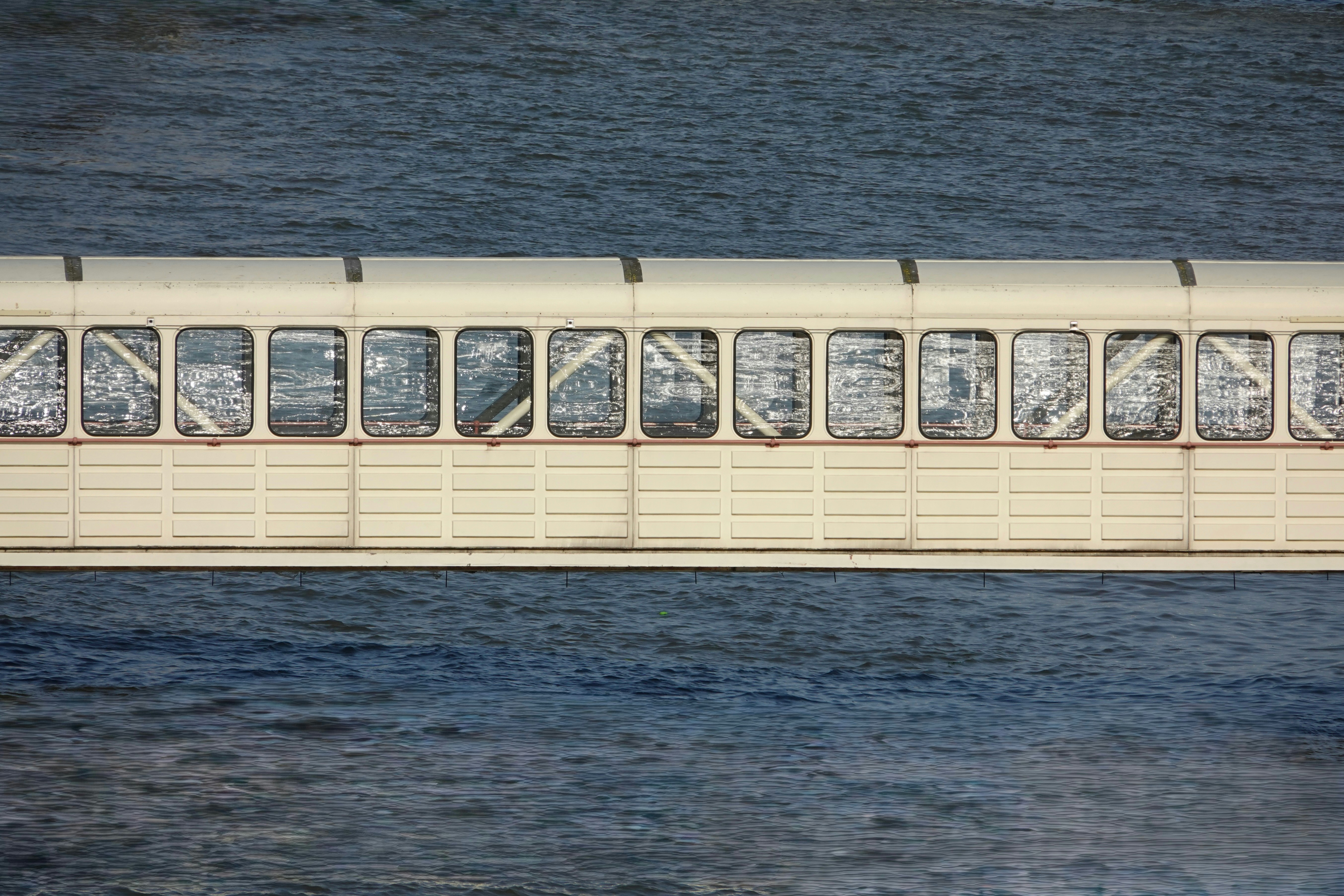 Sunlit Window Row Across a Beige River Barrier