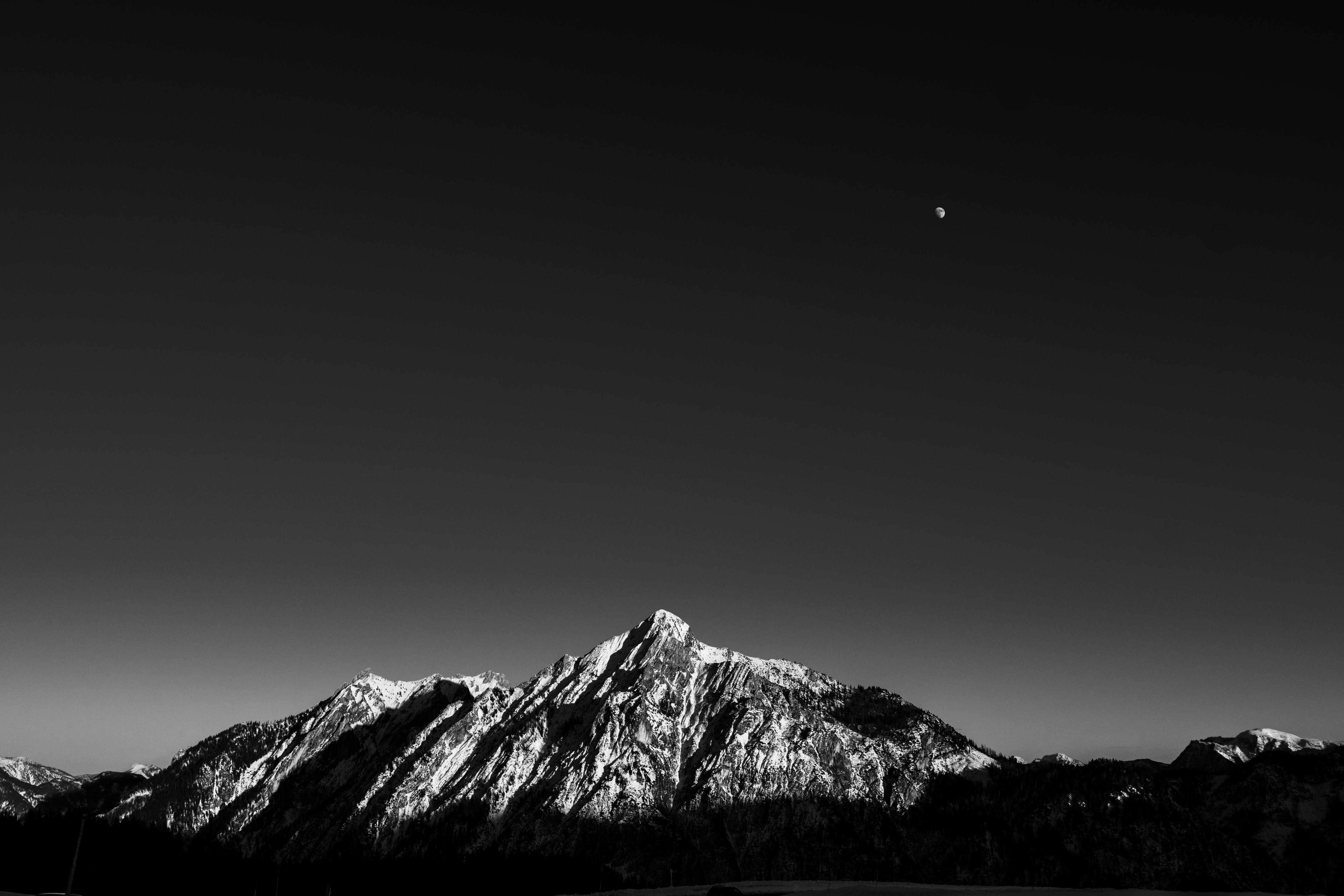 A "day for night" picture edited to look like a night scenery. Jan 2020. | Mountains and moon dominate the black and white sky.