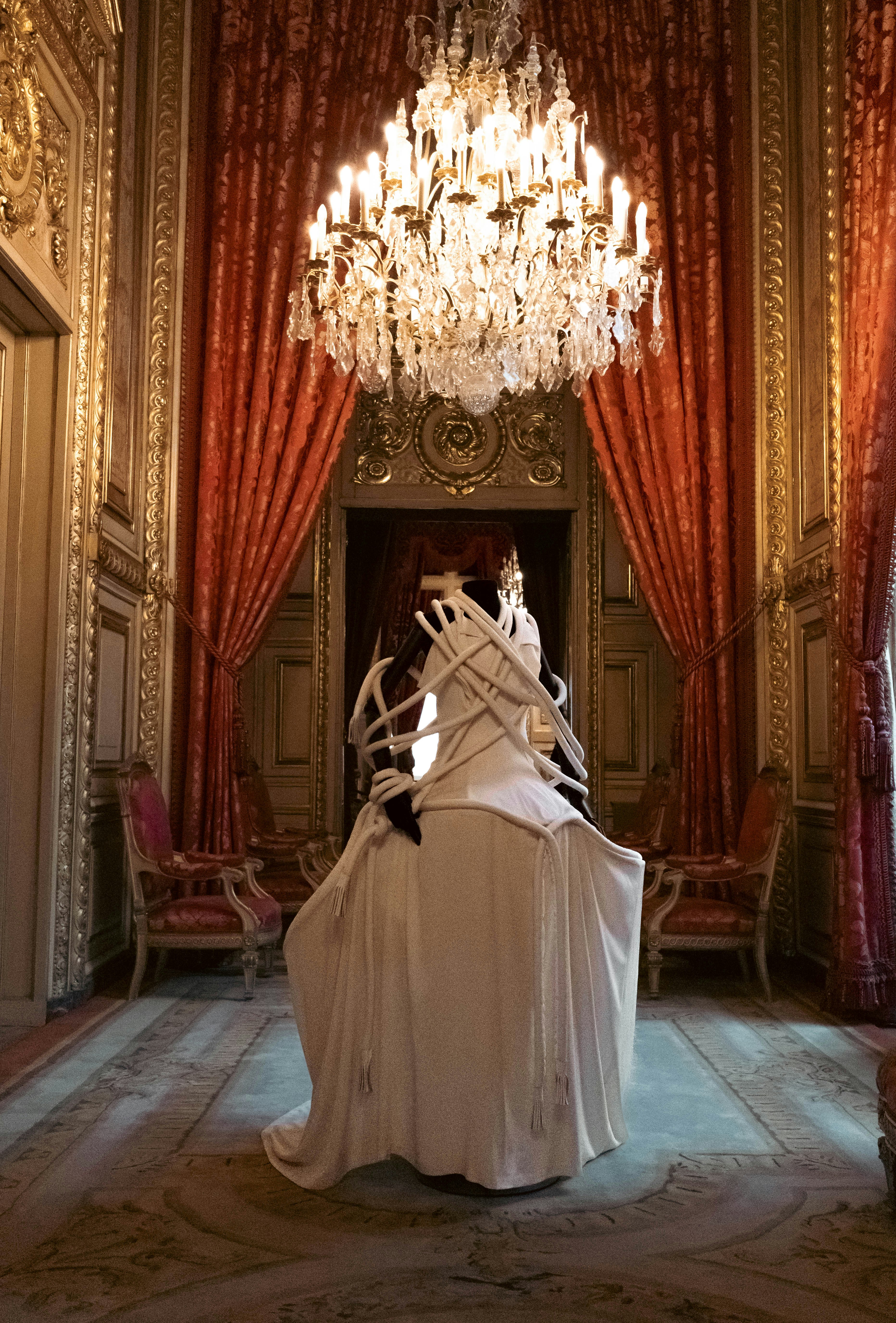 Spine-Threaded Gown Under a Crystal Crown in a Gilded Ballroom