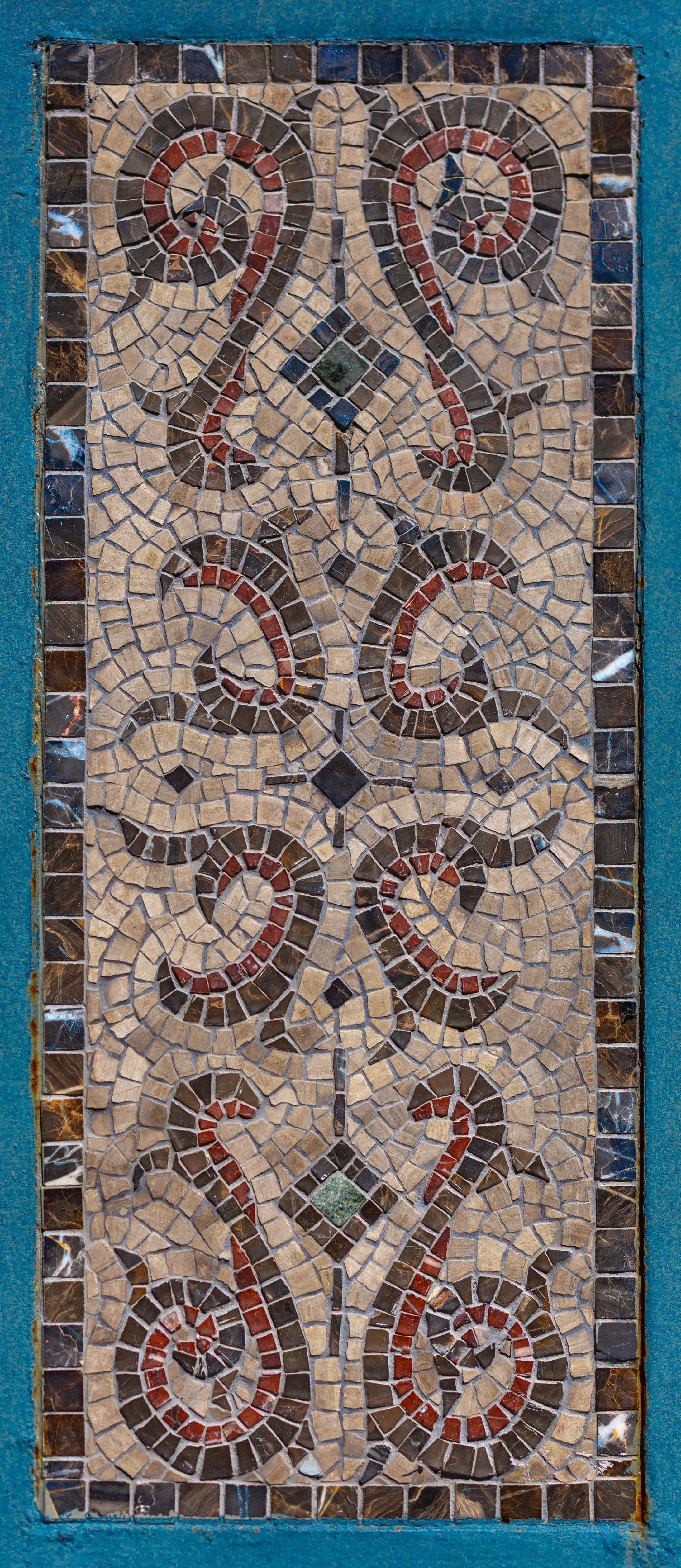 Mosaic tiles depict a symmetrical decorative design.