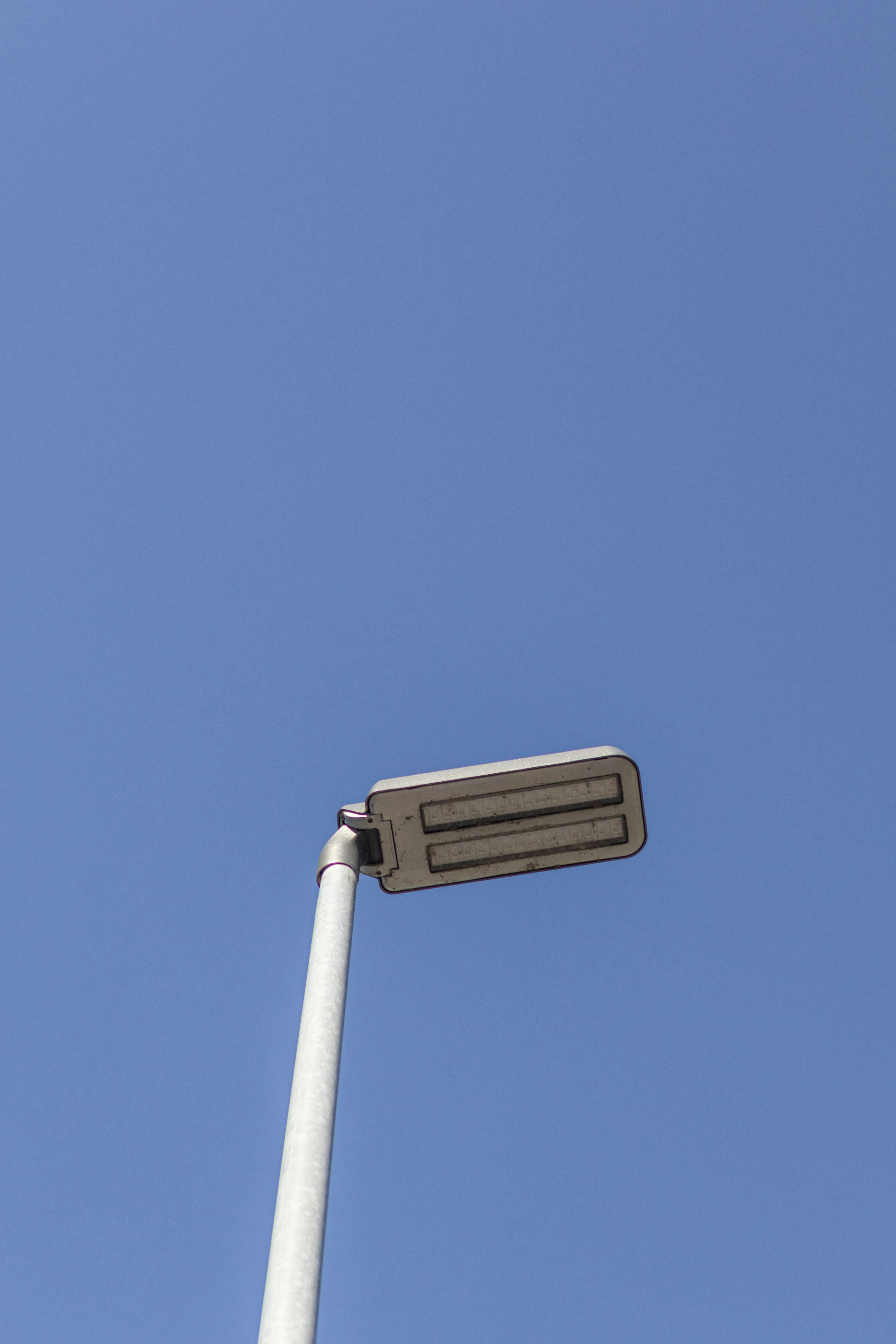 A streetlight against a bright blue sky.