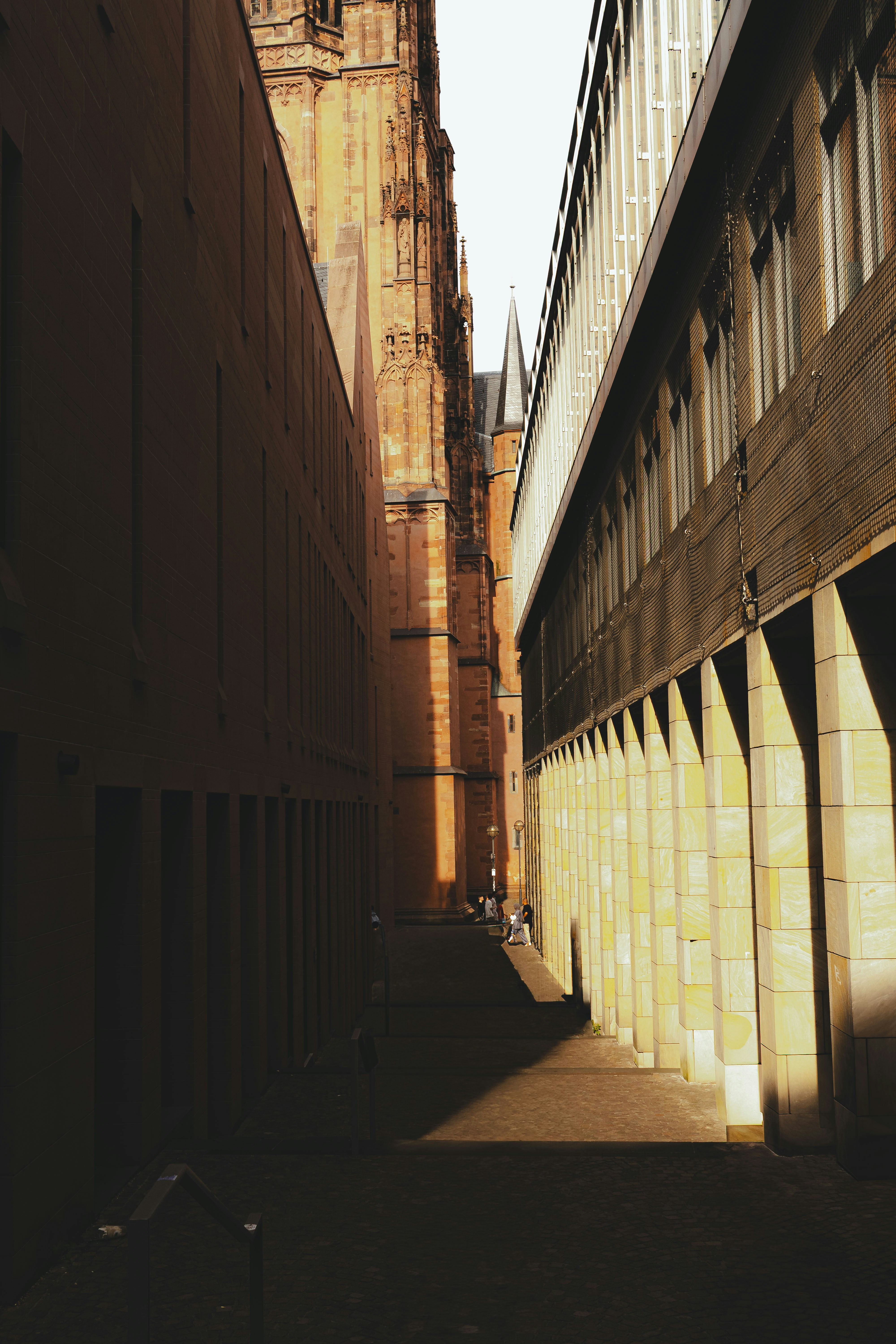 A narrow alleyway is flanked by tall buildings.